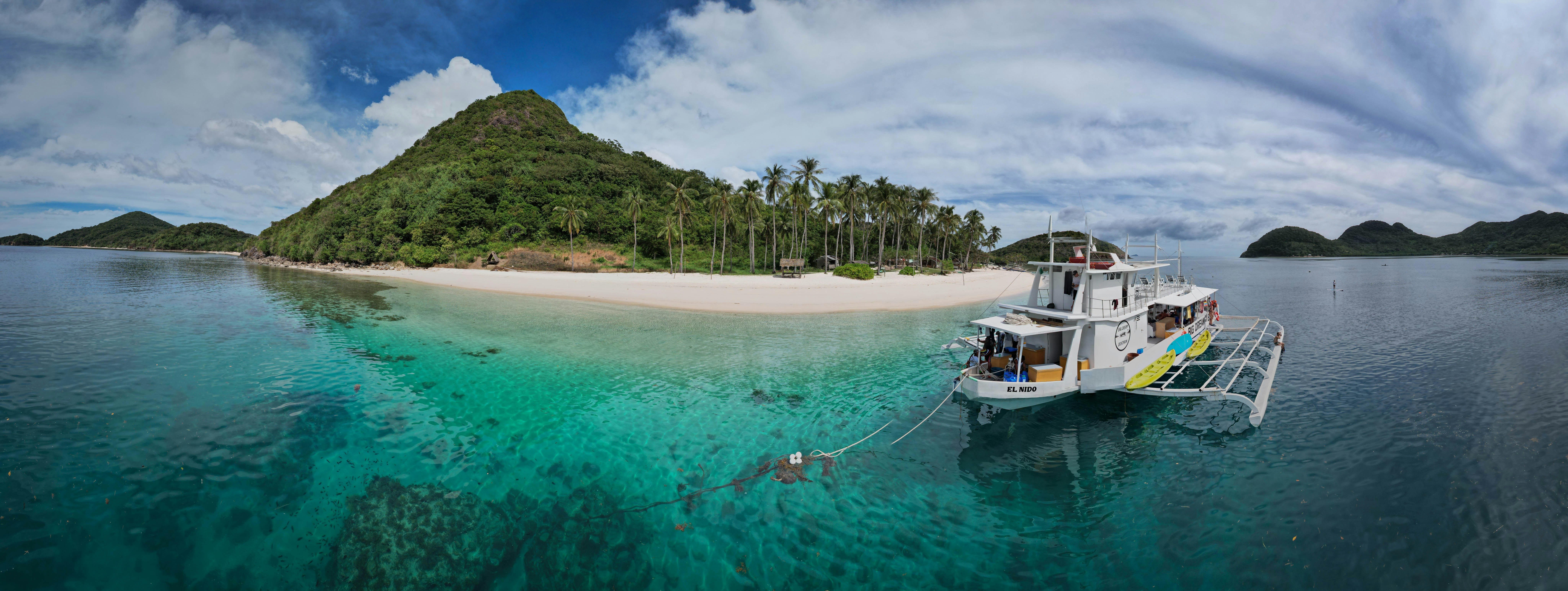 Emerald Calm at the Palm-Islet: Boat Anchored in Turquoise Waters