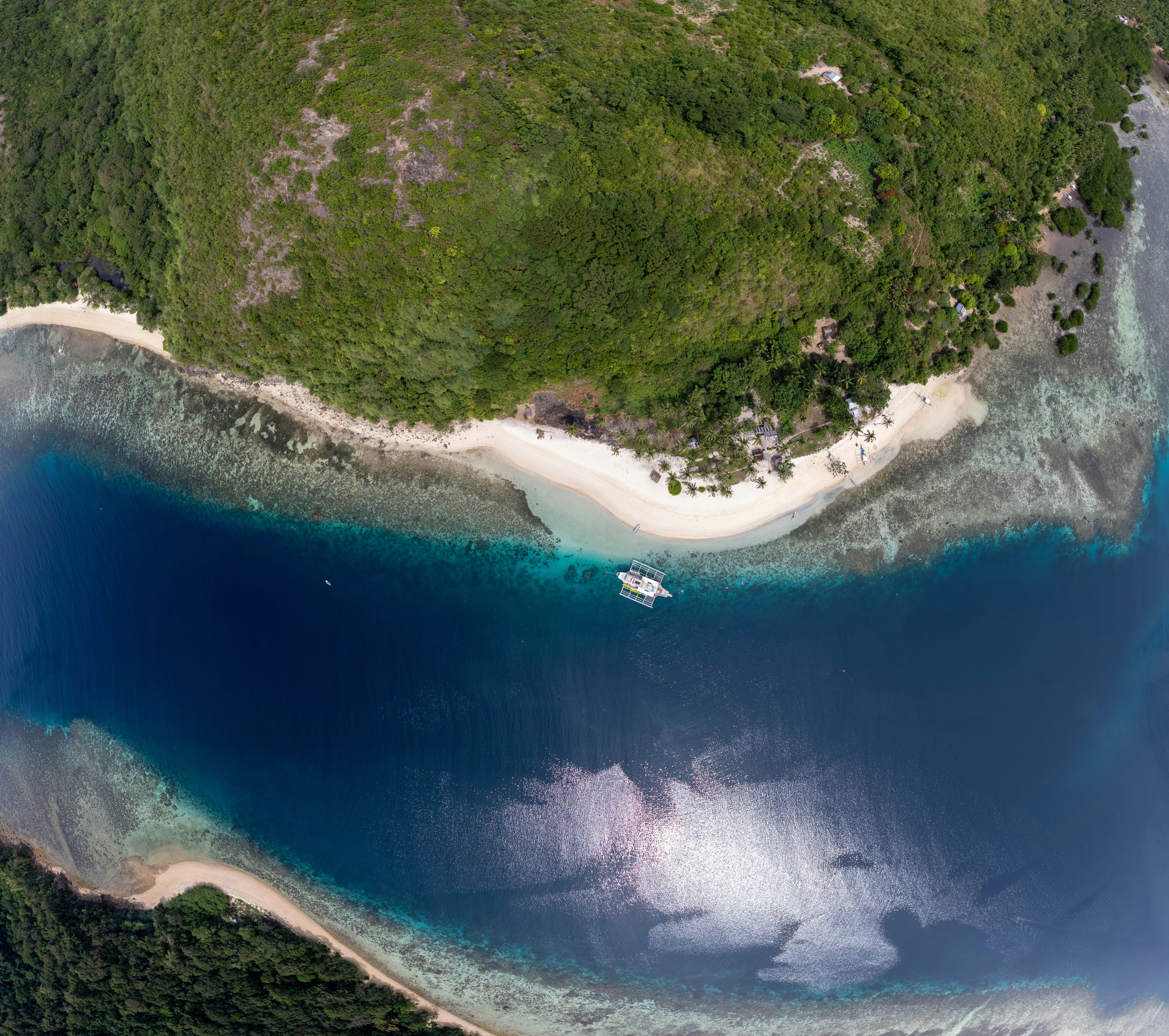 Aerial view of a tropical island with clear blue water.