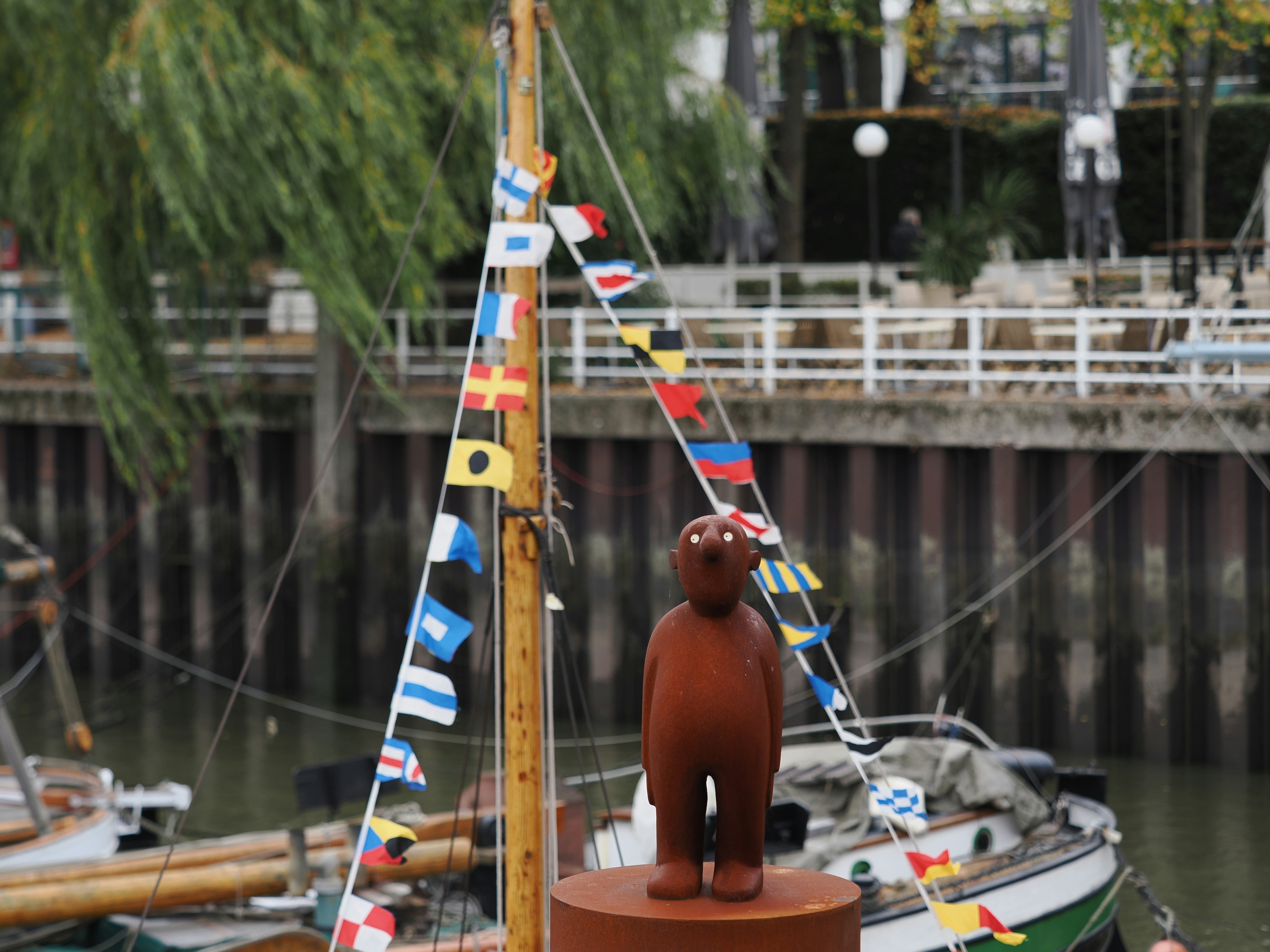 Sentinel on a Mast Among Colorful Pennants by the Canal