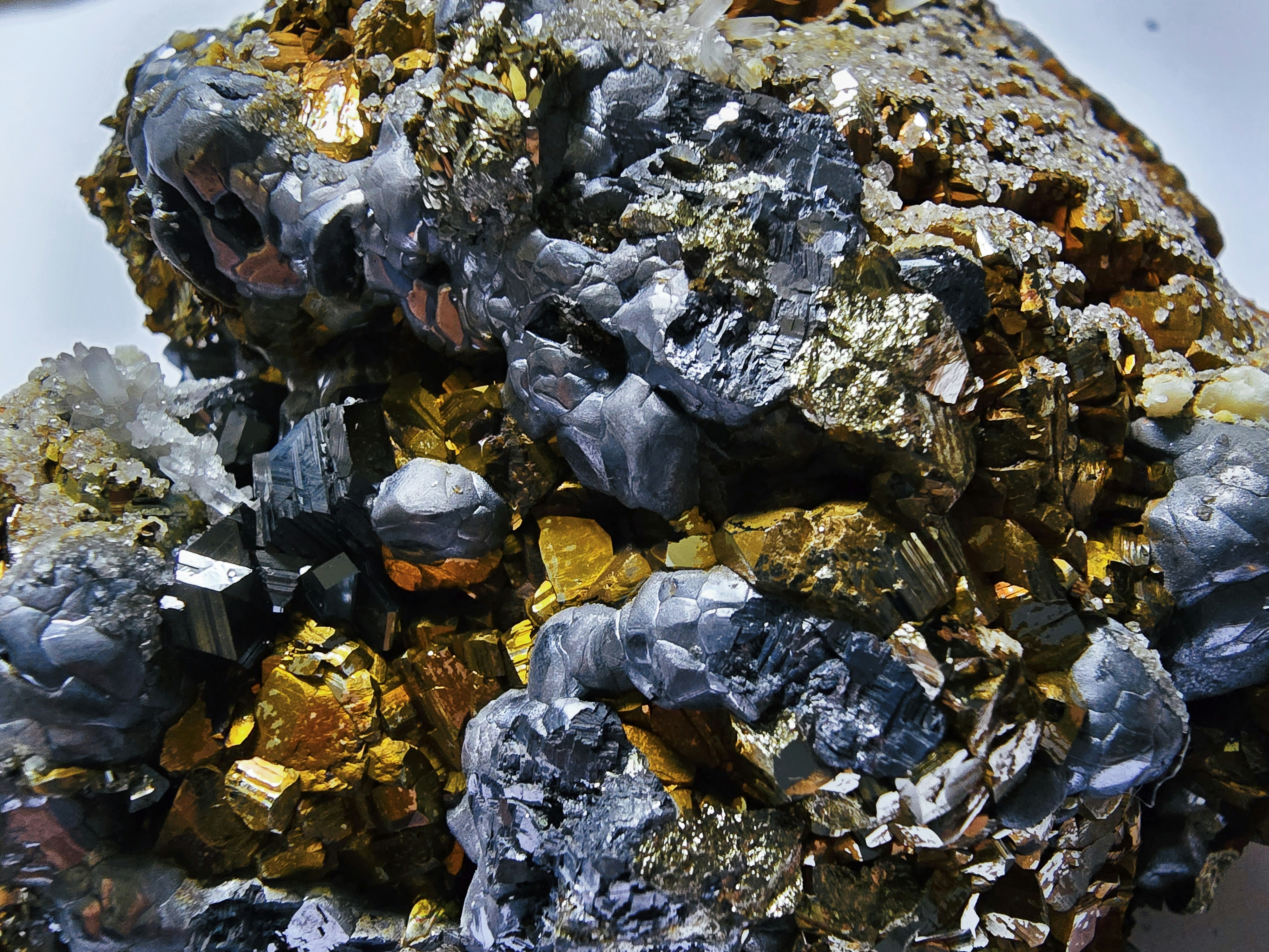 Close-up of metallic mineral cluster with gold and gray crystals. photo ...