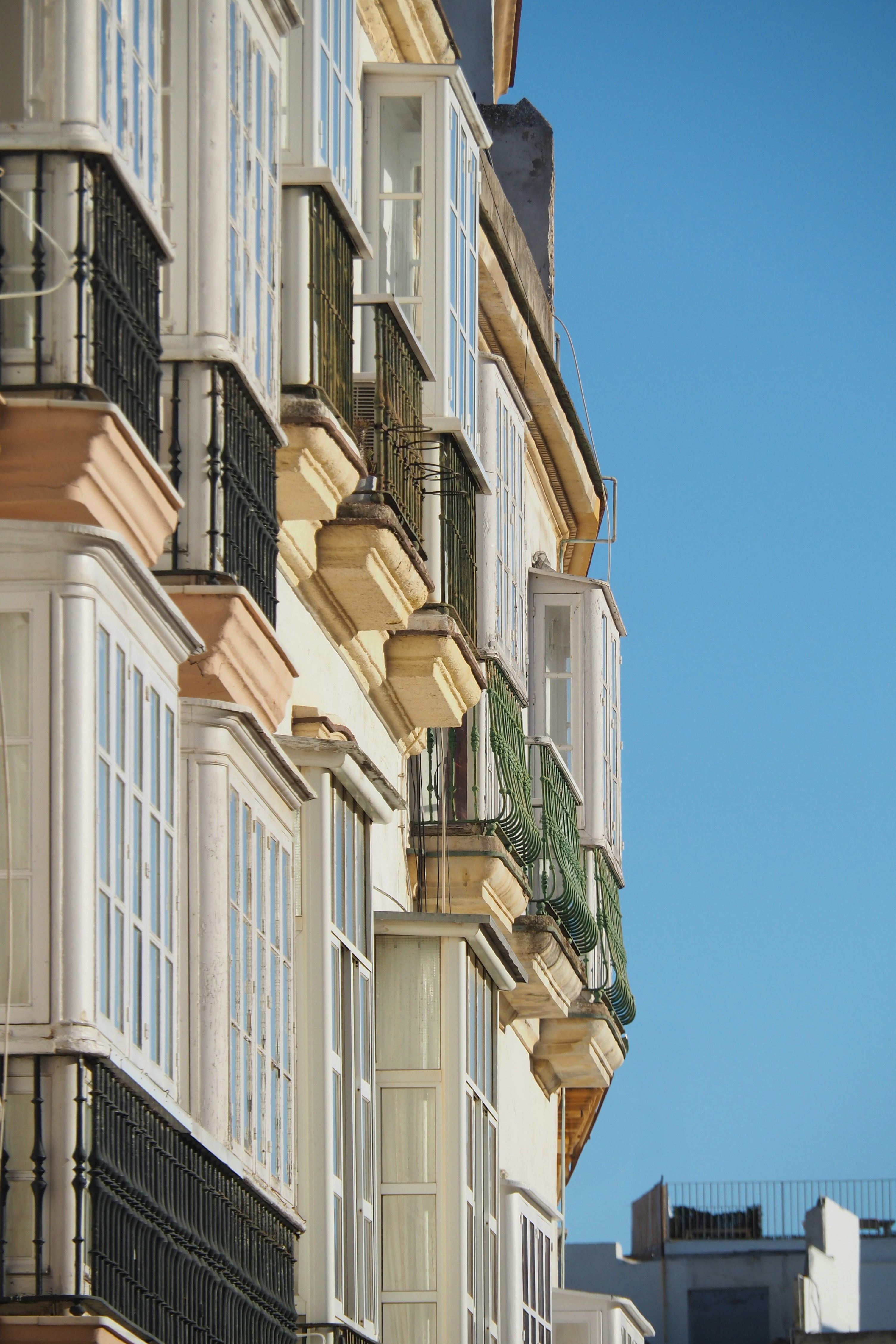 Balconies, tiny space, big vibes. | Ornate balconies on a building against blue sky
