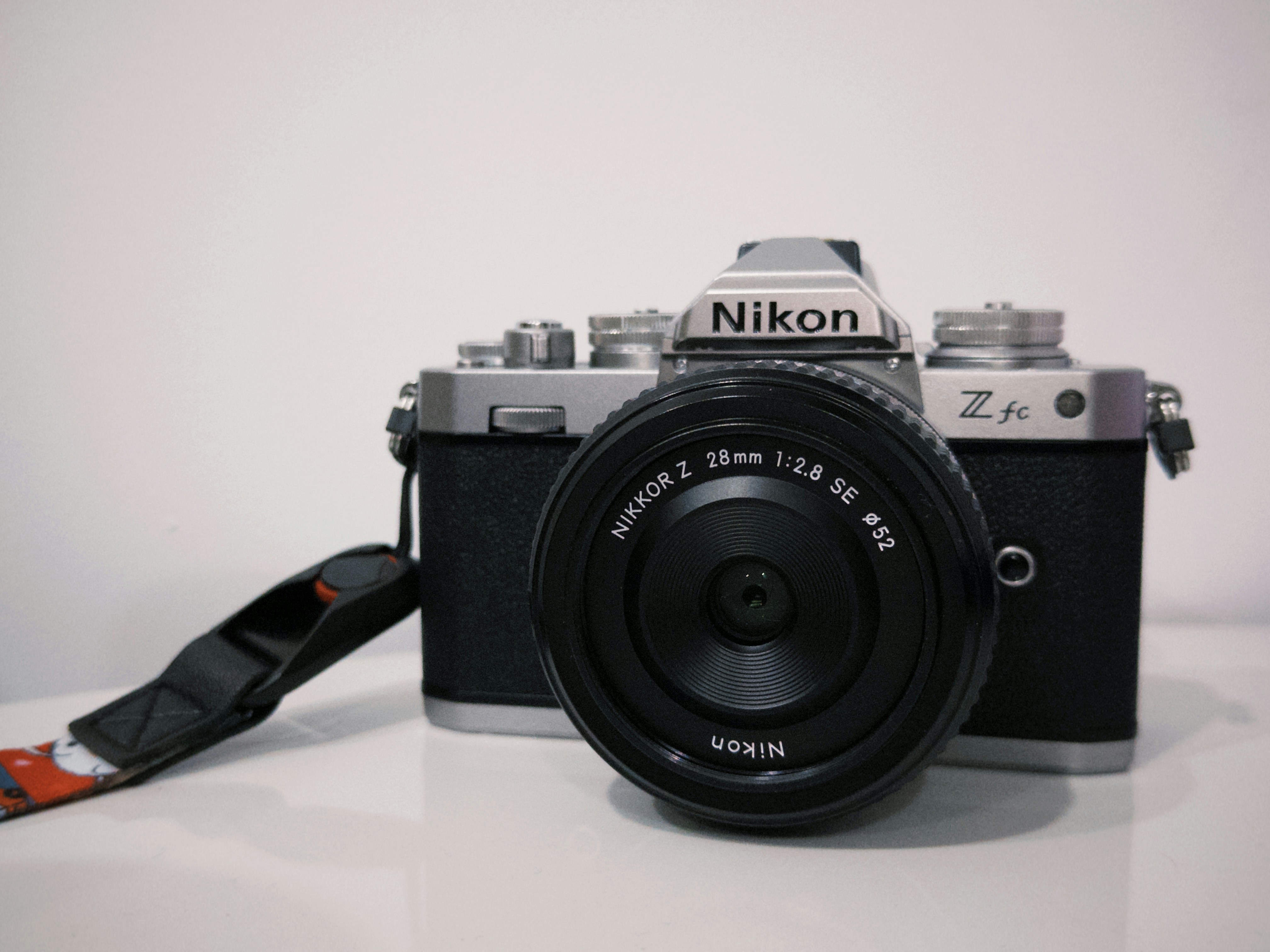 A vintage nikon camera with a lens attached.
