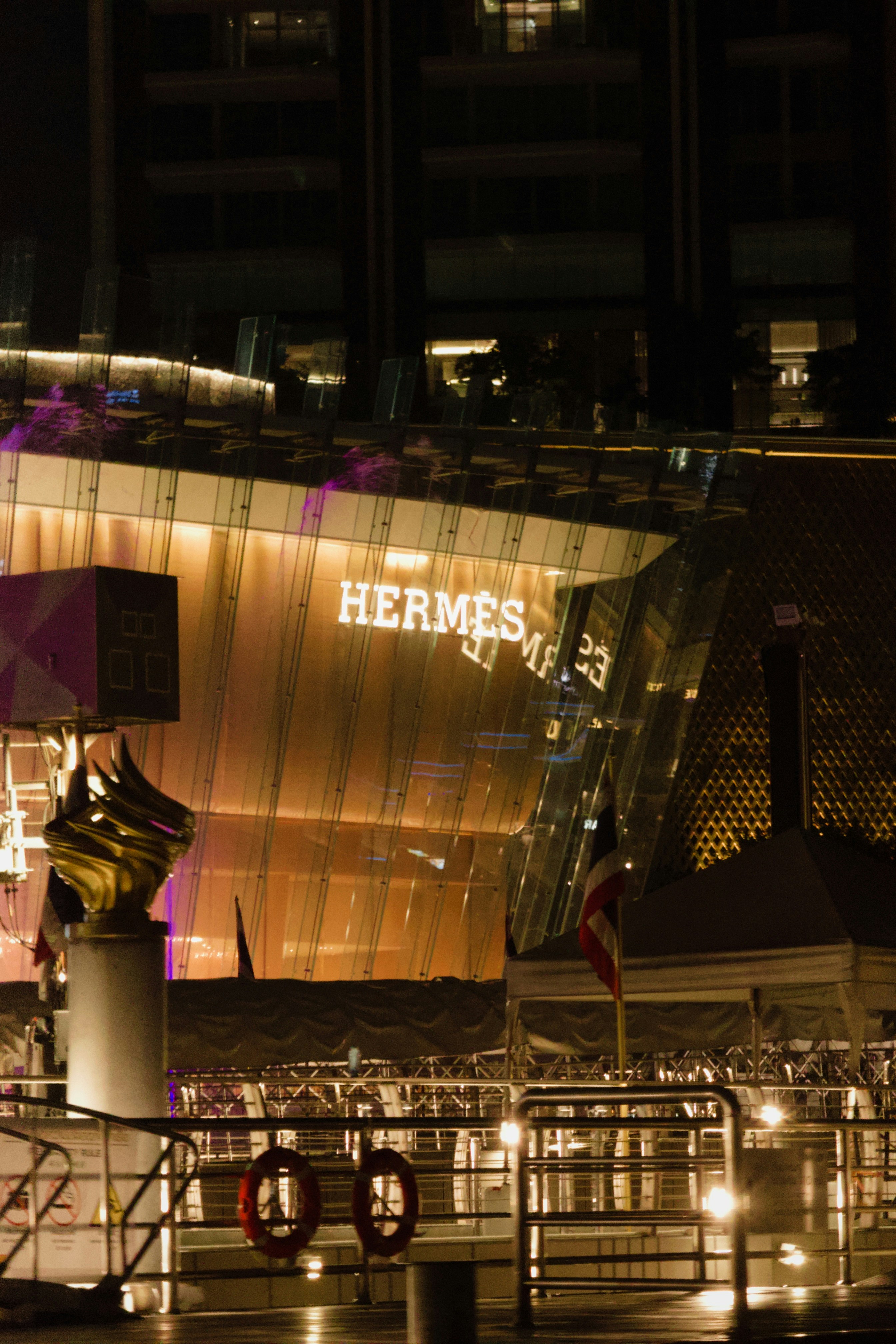 Hermes building illuminated at night with city lights