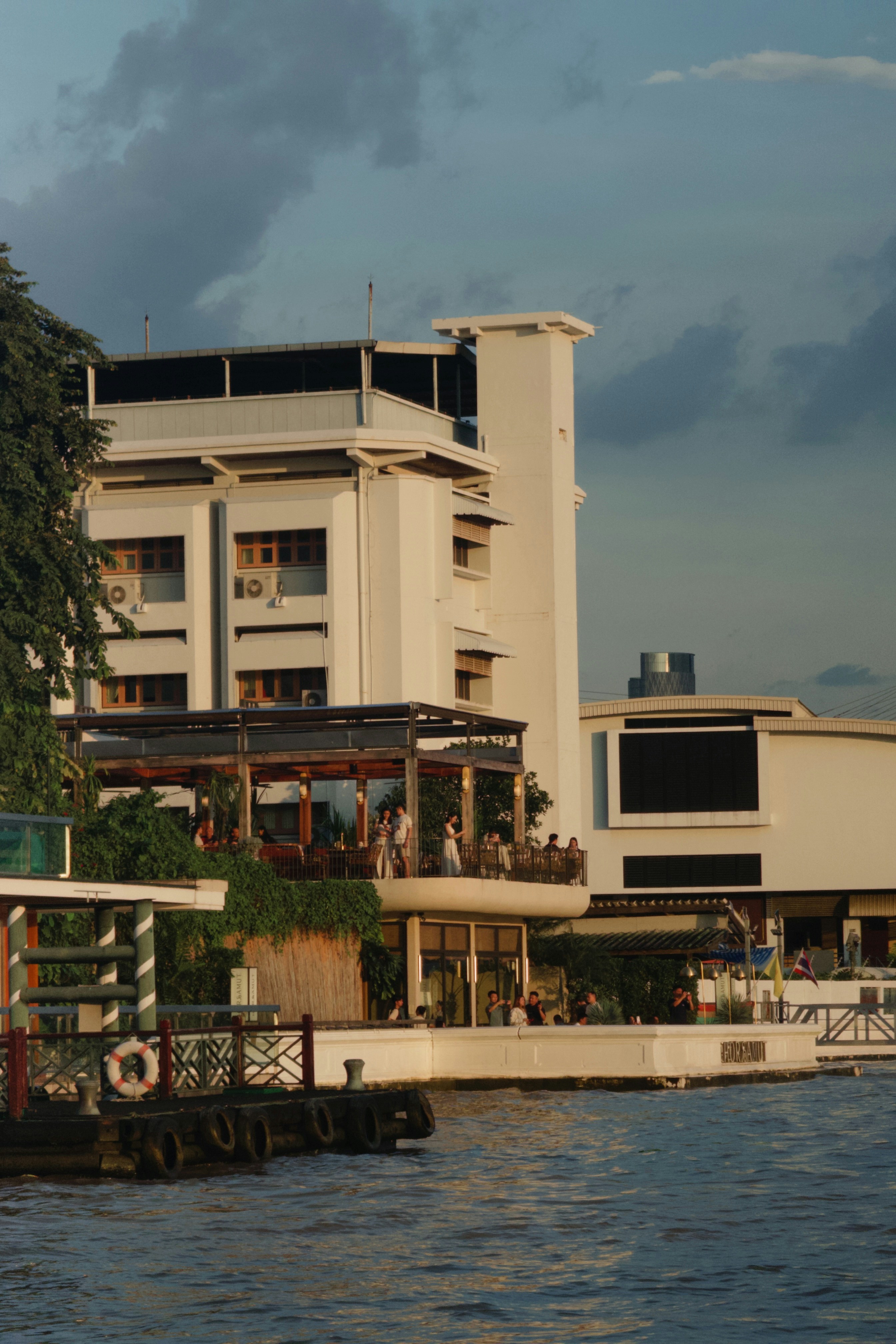 Buildings on the waterfront with people enjoying outdoor seating.