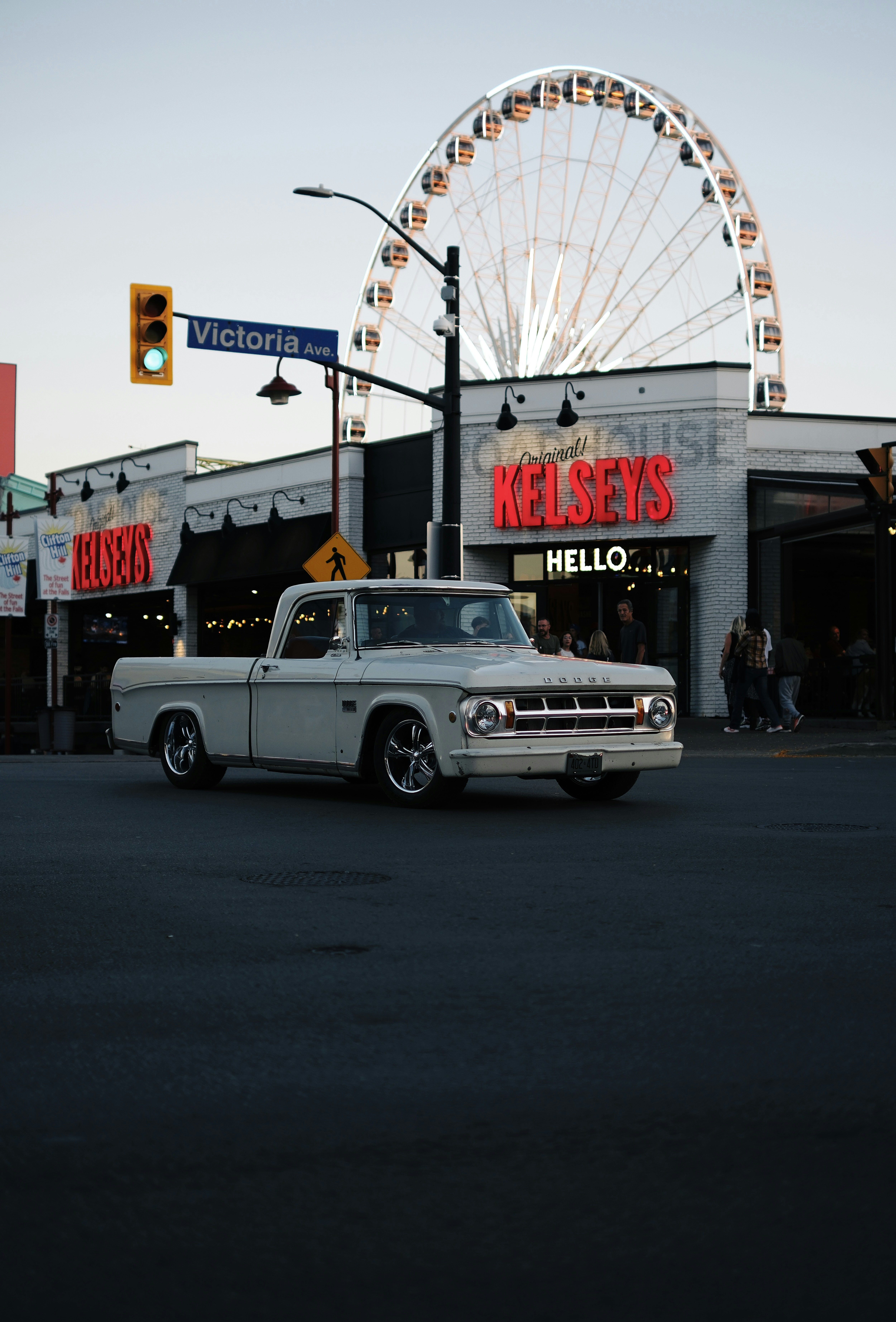 Instagram - @kaprion | White vintage truck drives past kelseys restaurant with ferris wheel.