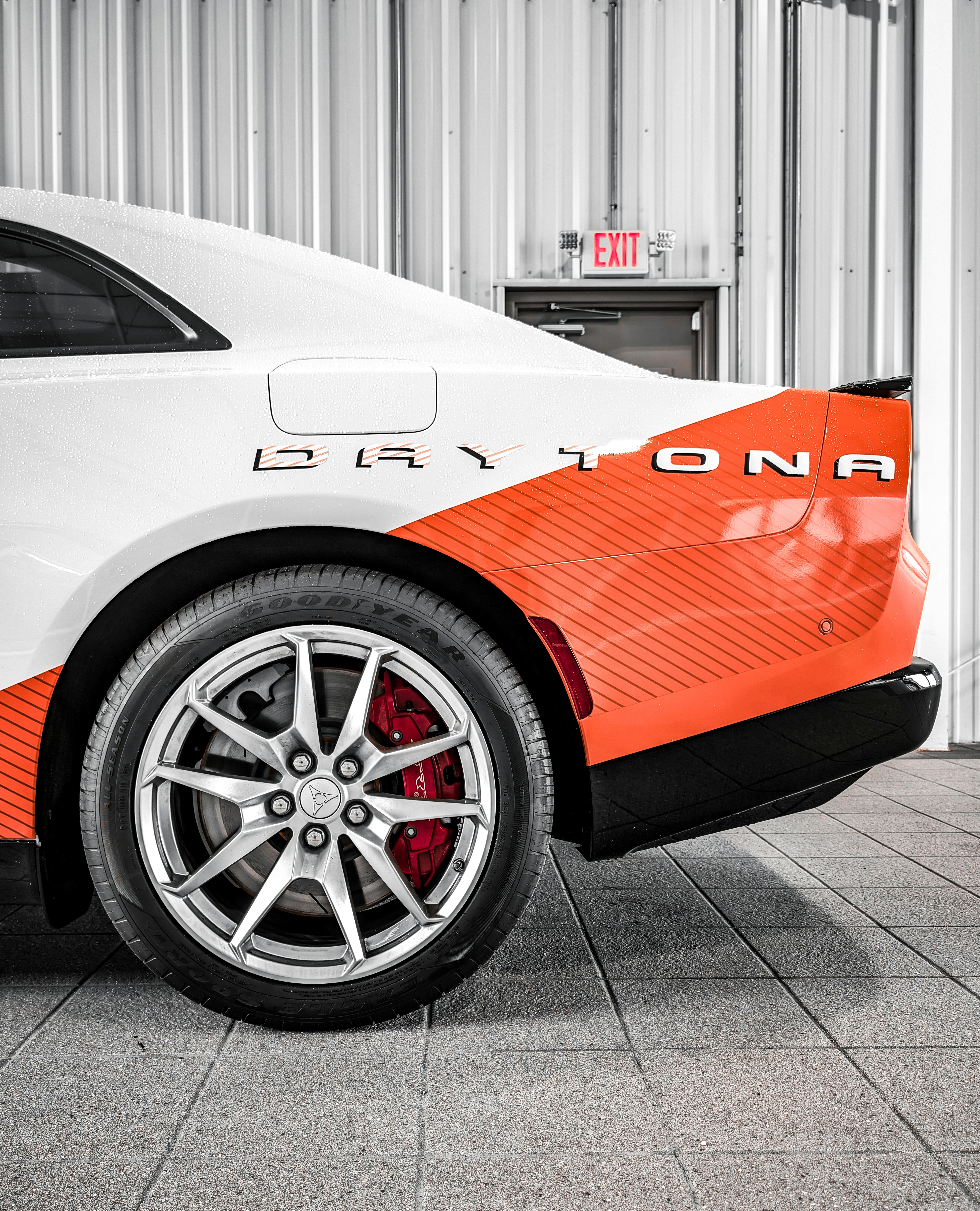 An incredible display of automotive artistry! The vibrant orange graphics and sleek lines are breathtaking. This performance car perfectly captures a feeling of pure speed and masterful modern design. | White and orange sports car with daytona branding