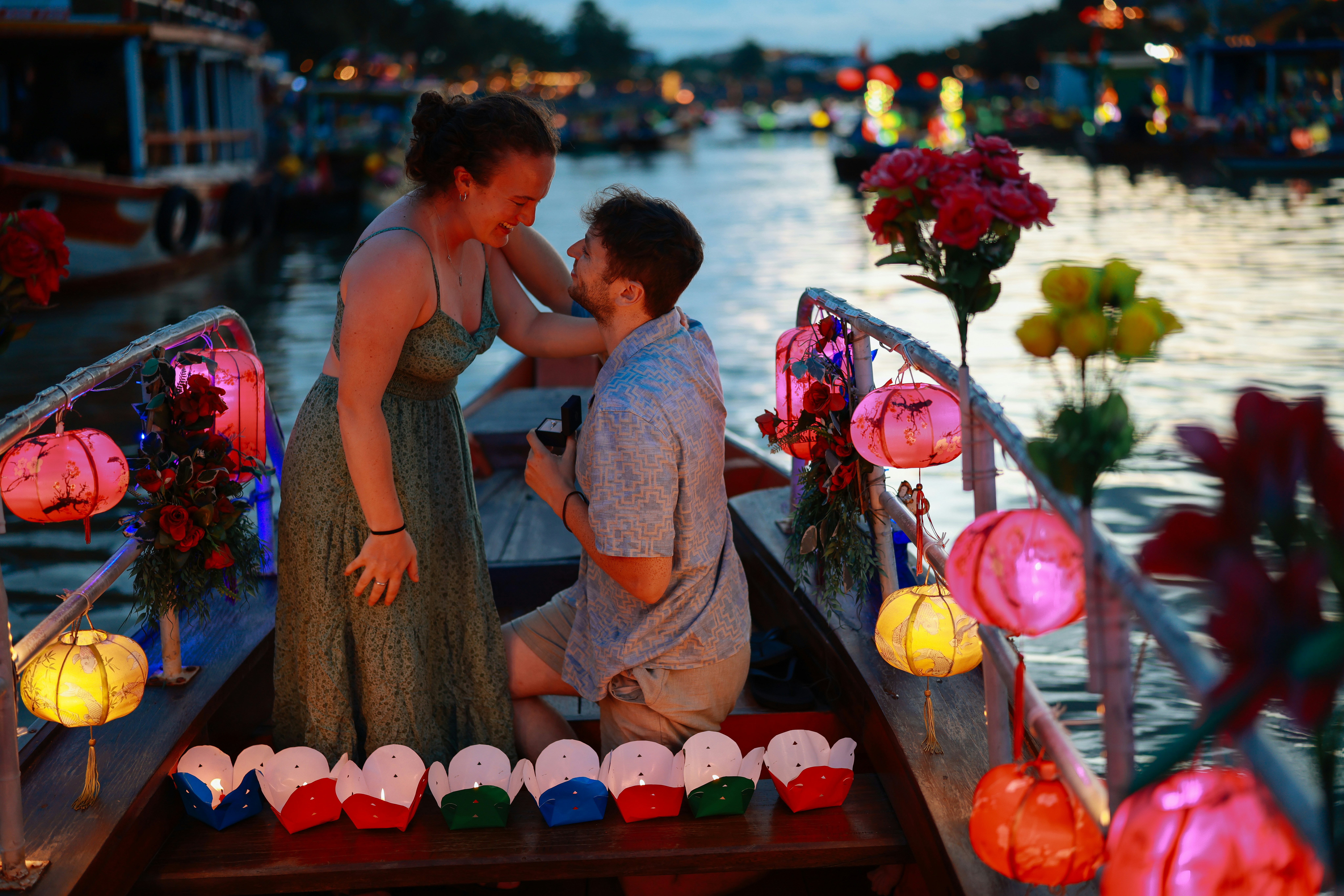 Man proposes to woman on boat with lanterns
