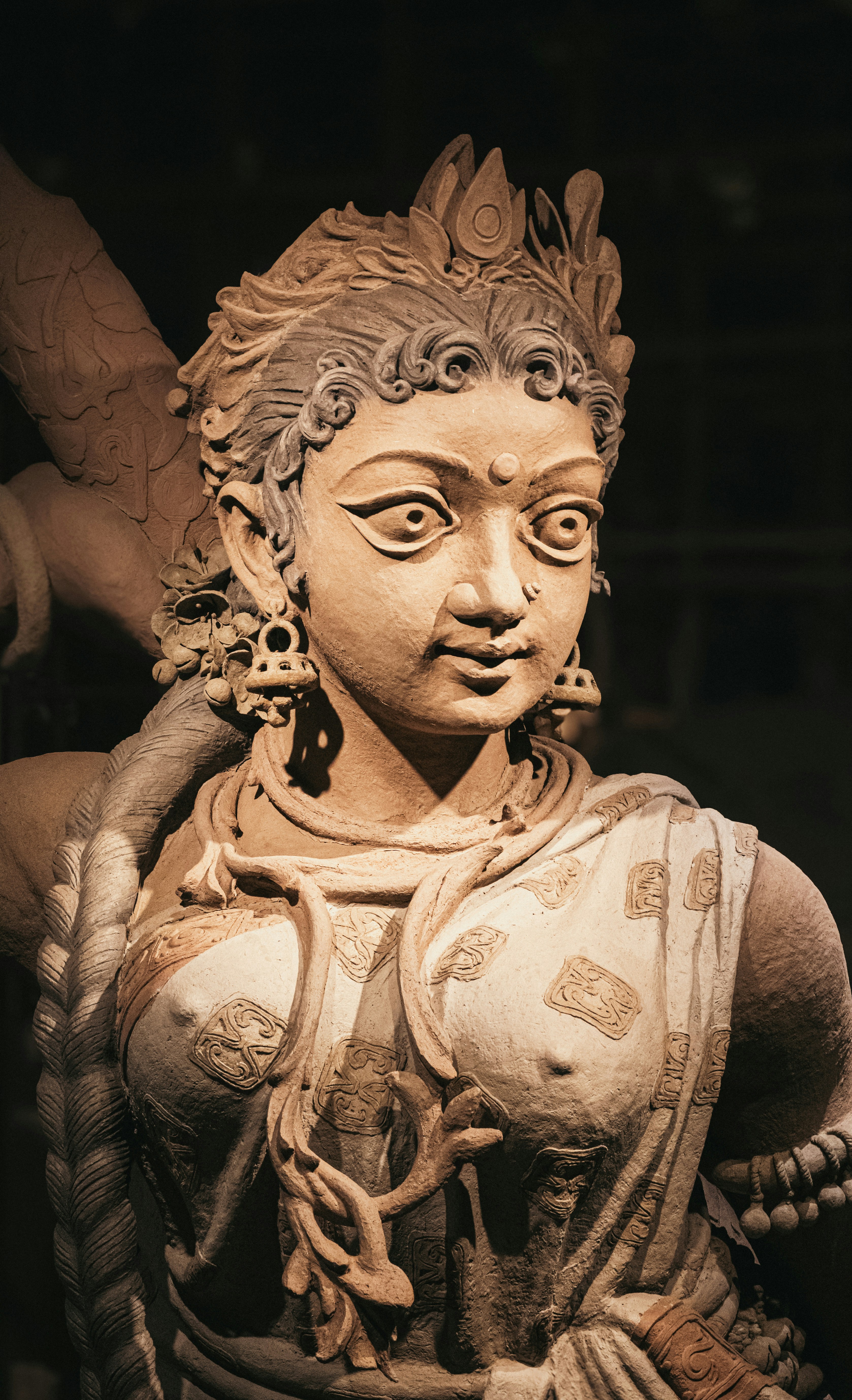 Intricate sculpture of a woman with elaborate jewelry.