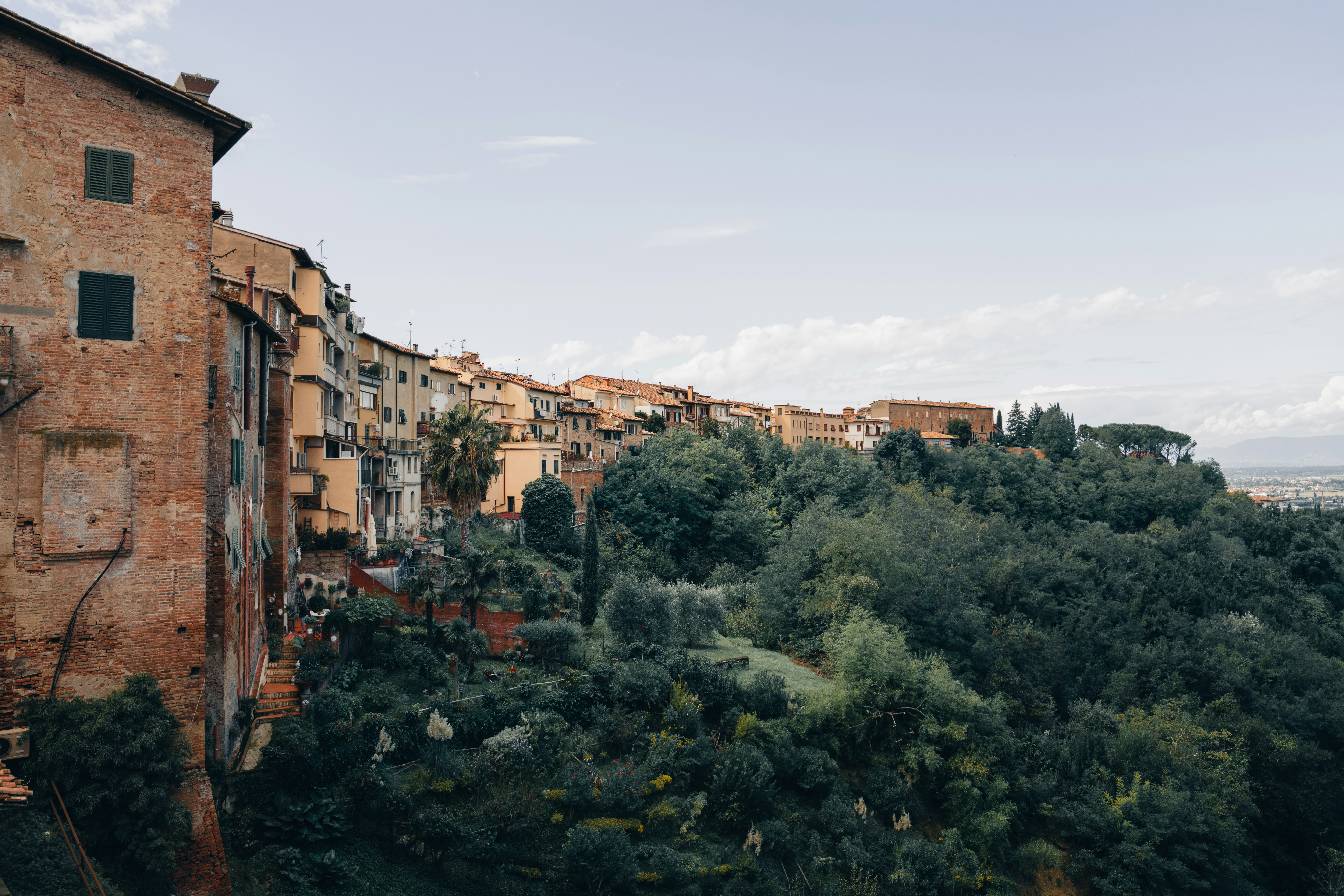 Charming hillside village nestled among vibrant greenery, showcasing a blend of rustic architecture and nature. The scene evokes a sense of tranquility and timelessness.