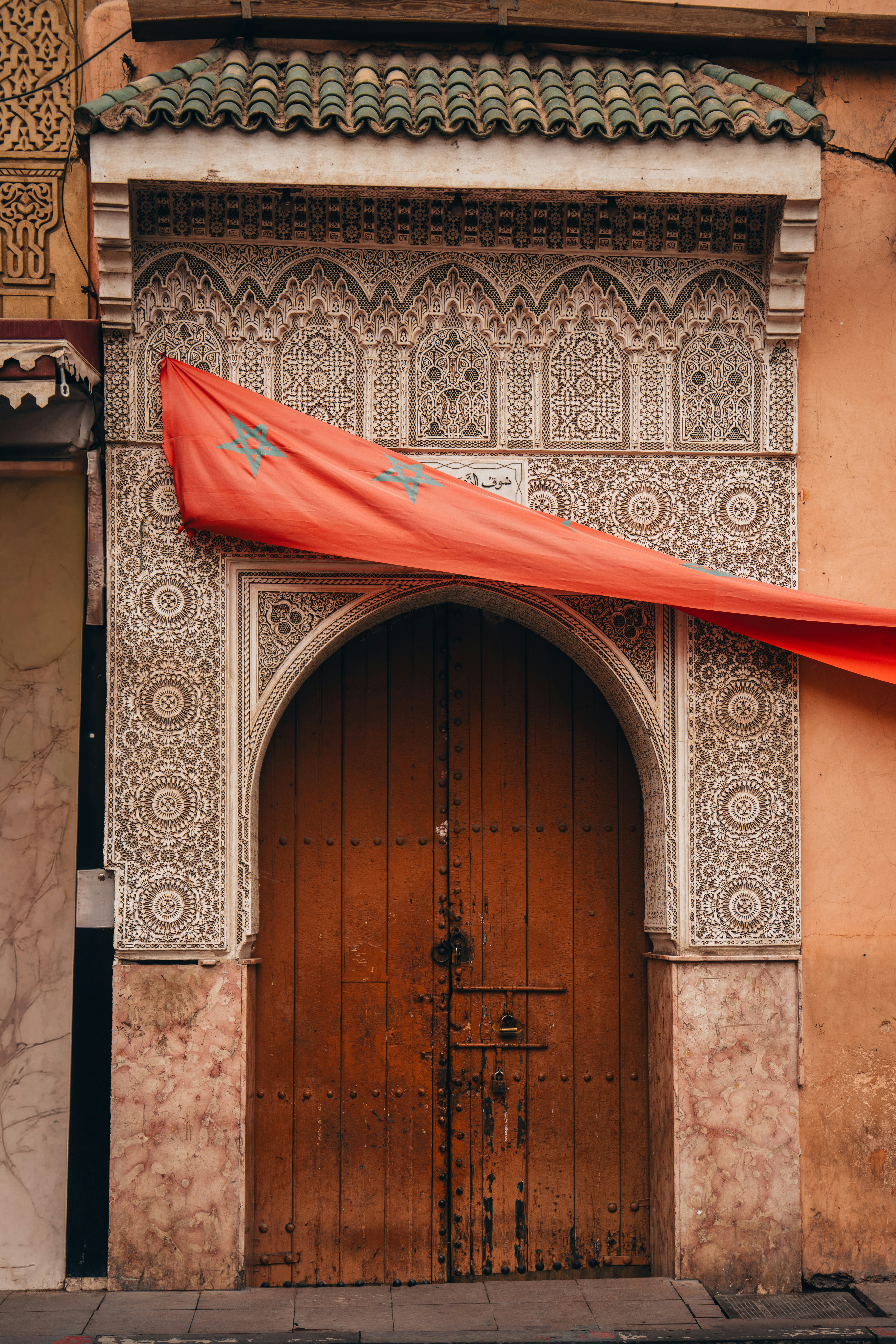 Ornate wooden door with red fabric draped over archway