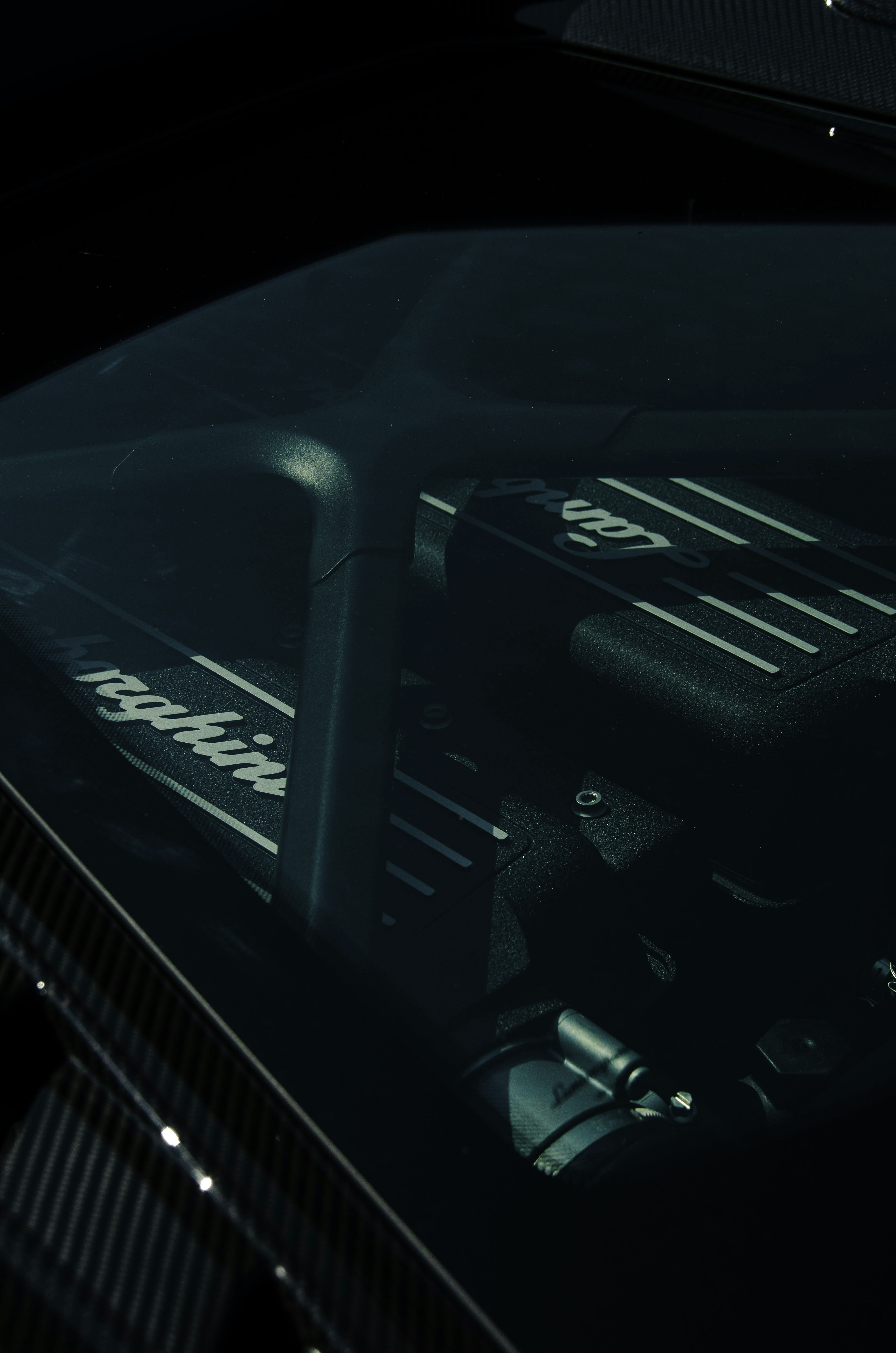 Close-up view of a high-performance engine, showcasing intricate details and craftsmanship through a glass panel.