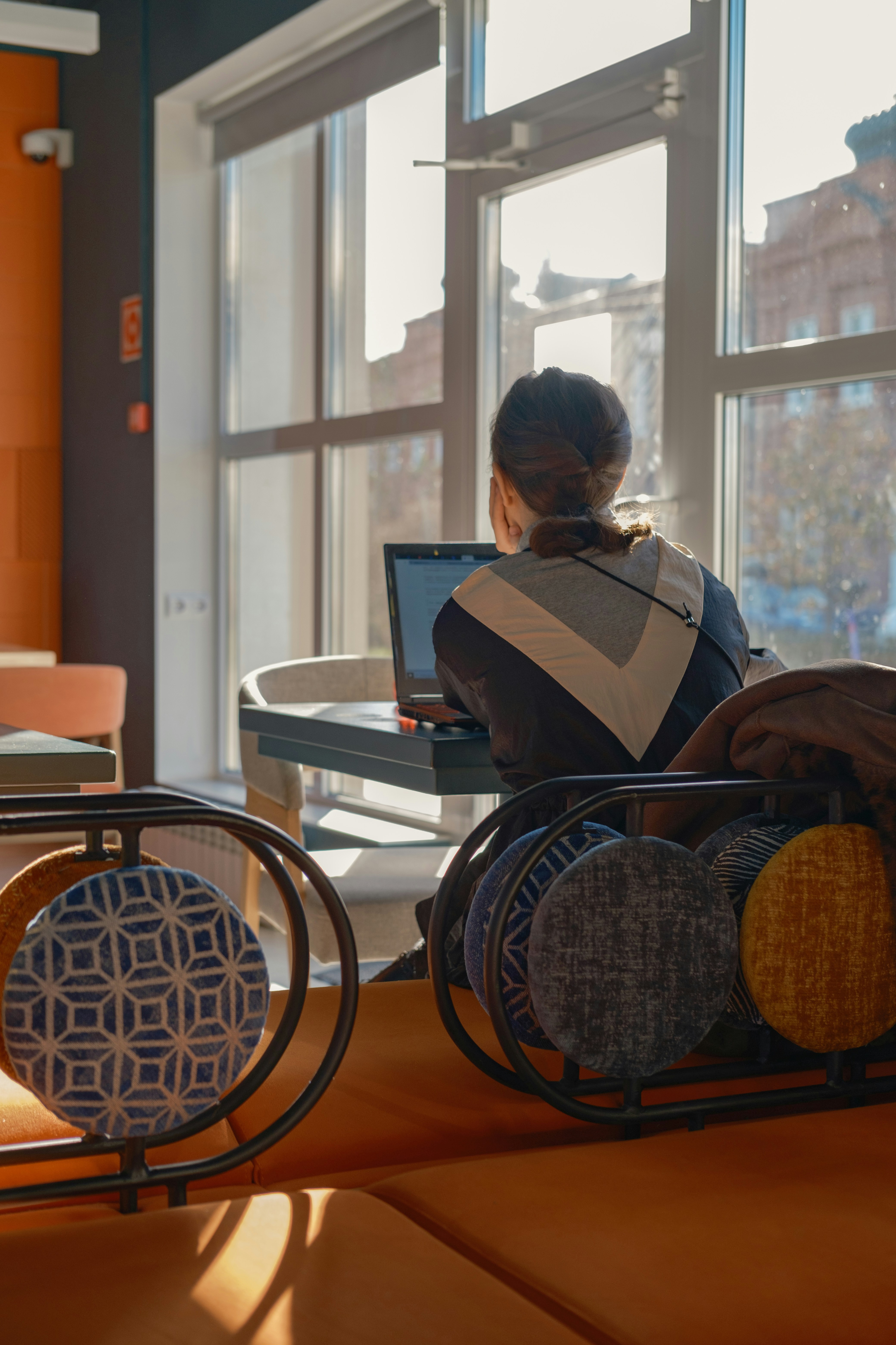 Laptop glow in a sunlit cafe: a quiet study session by the window