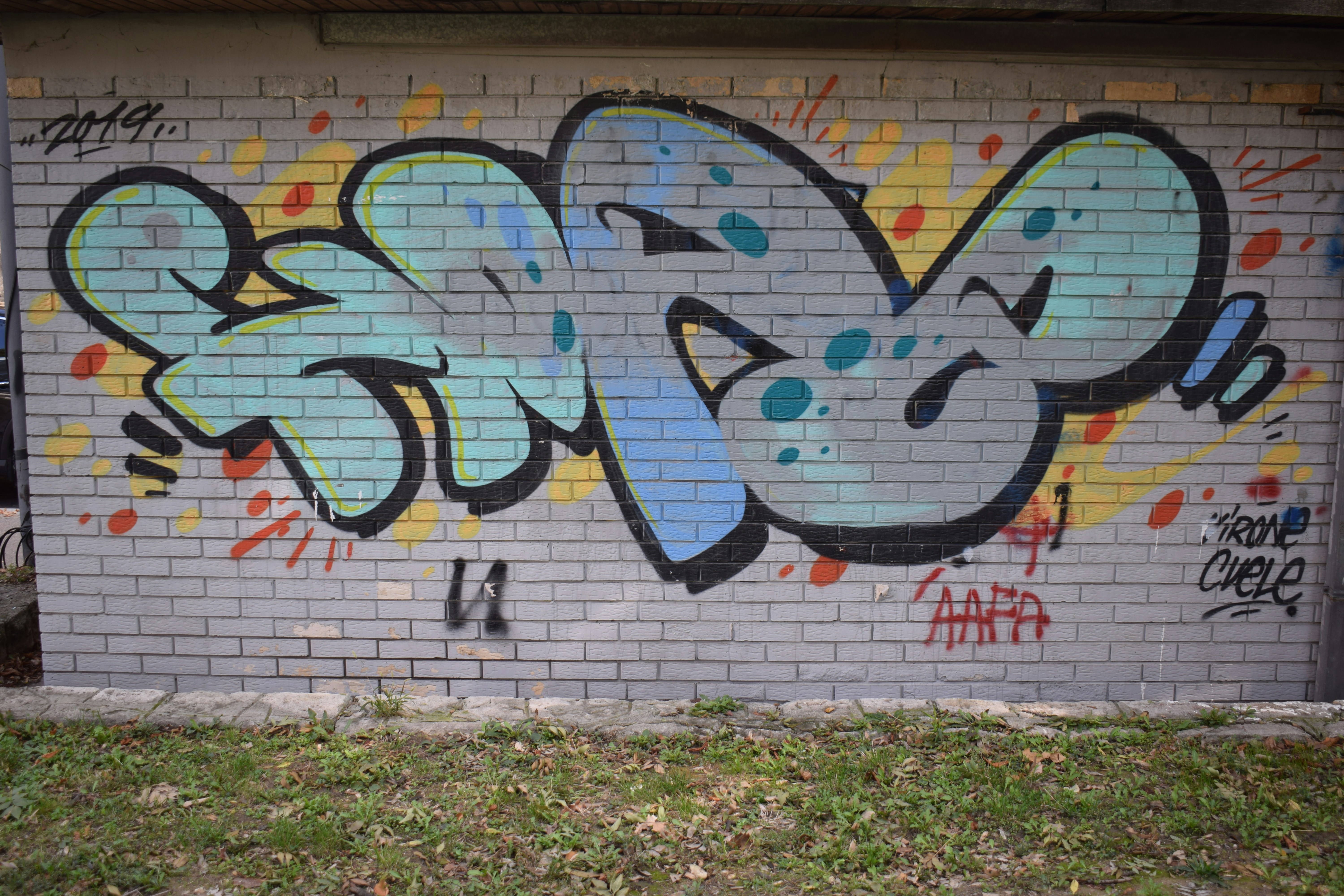 Vibrant graffiti mural showcasing abstract shapes and playful colors on a brick wall, highlighting urban artistry.