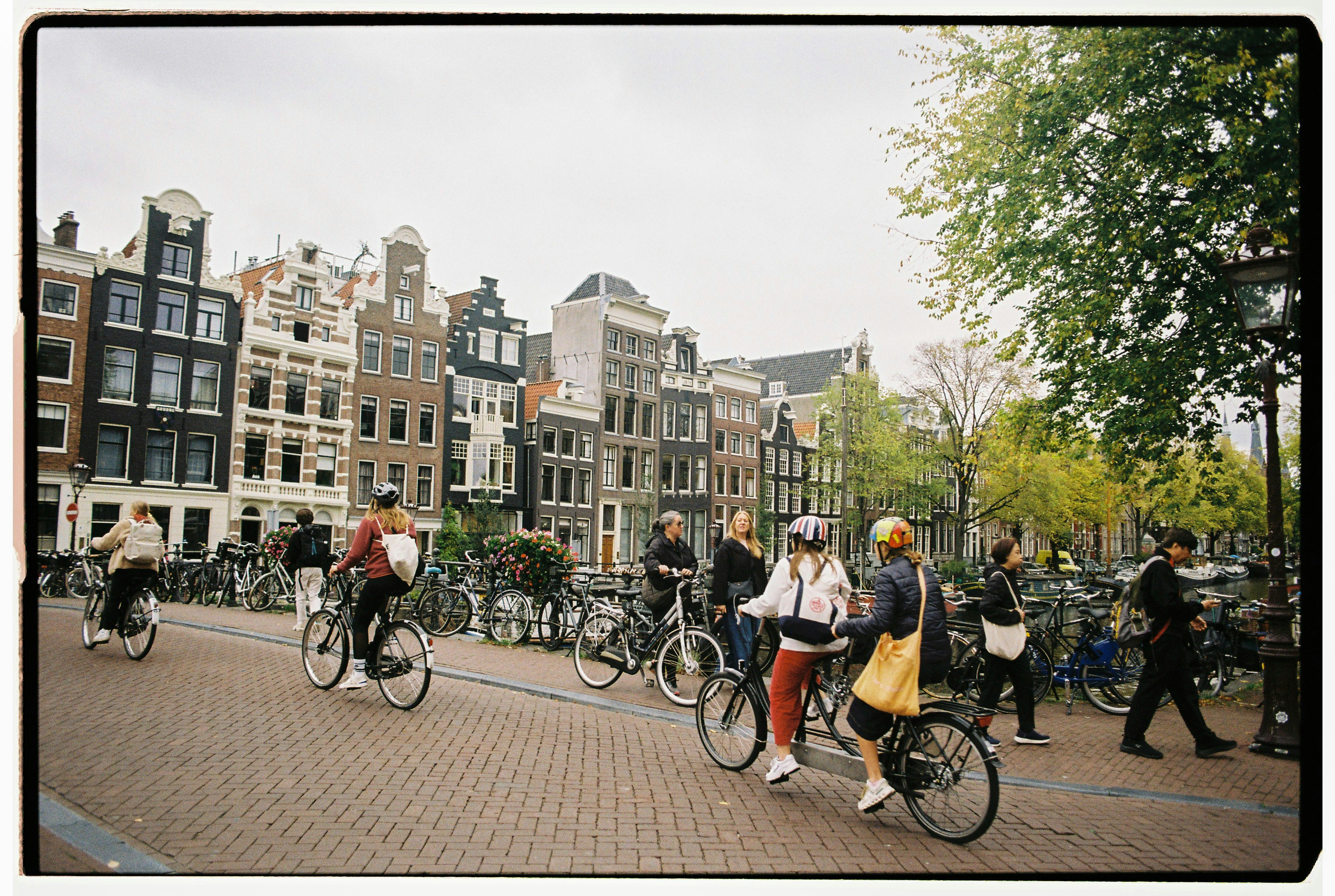 Pedal Parade Along Amsterdam's Brick-Fronted Canal Row