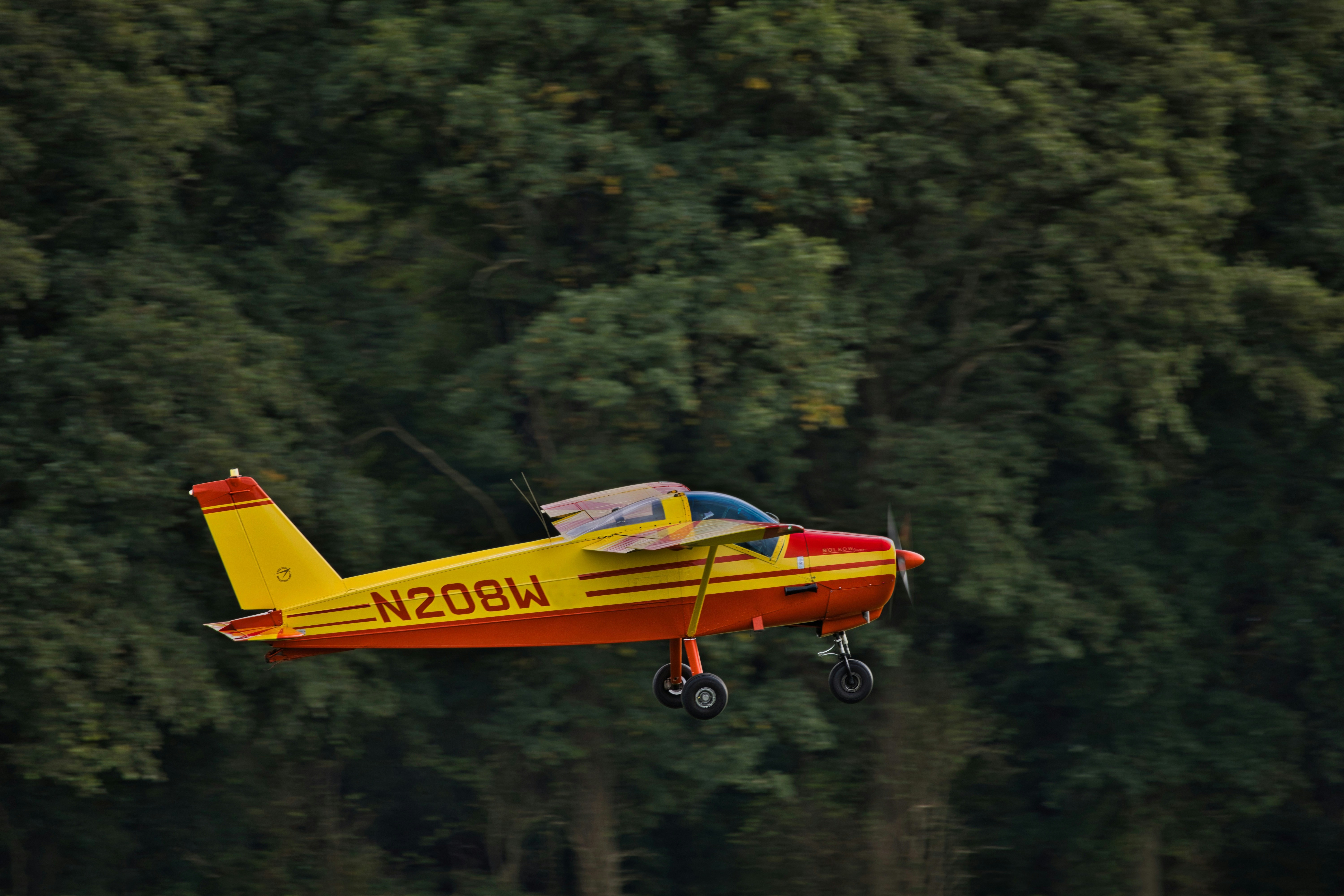 Canary Arrow Over Pines: A Bright Yellow Aerobatic Flight