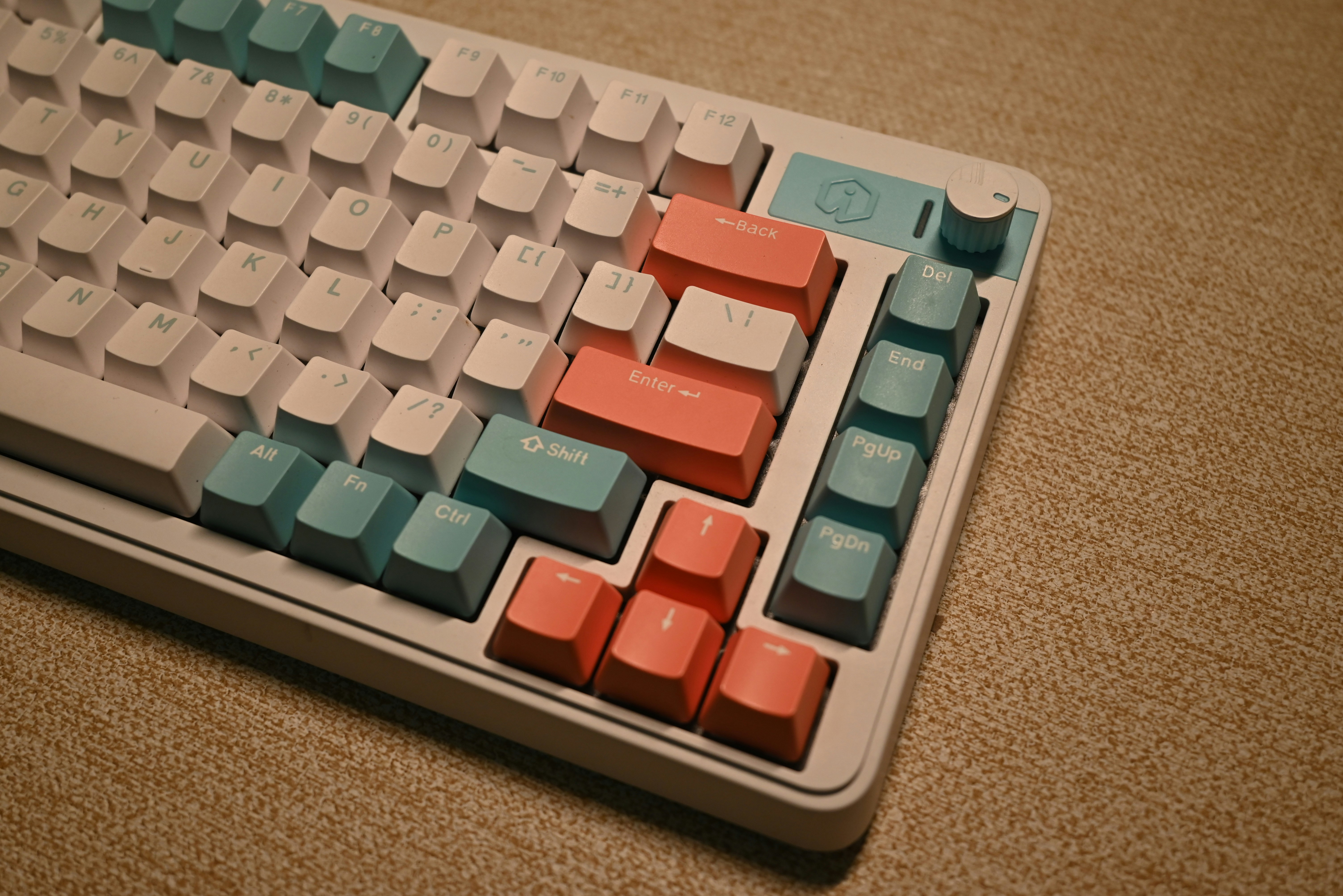 White keyboard with coral and teal keycaps on textured surface photo ...