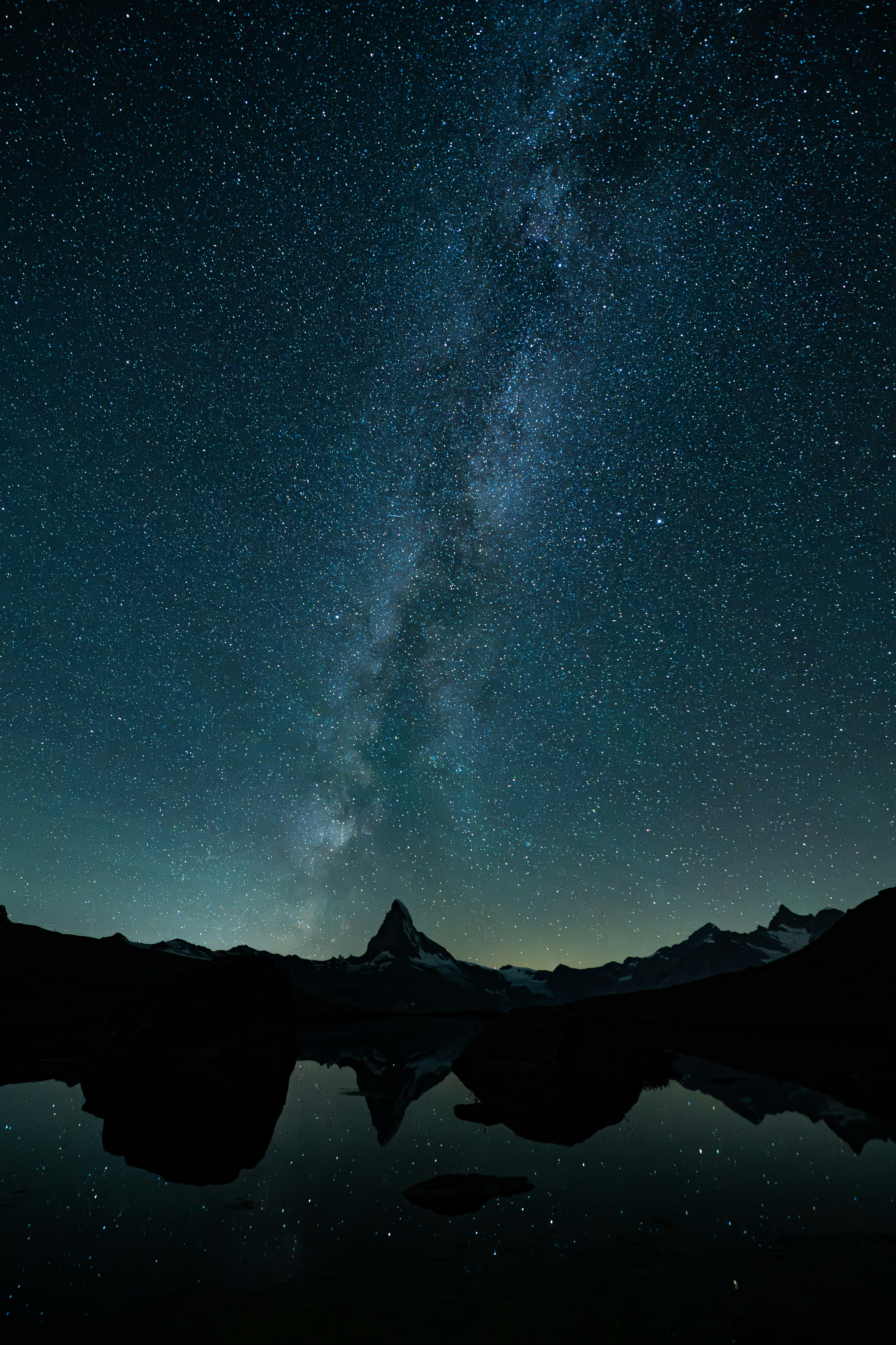 Milky way over a mountain reflected in water