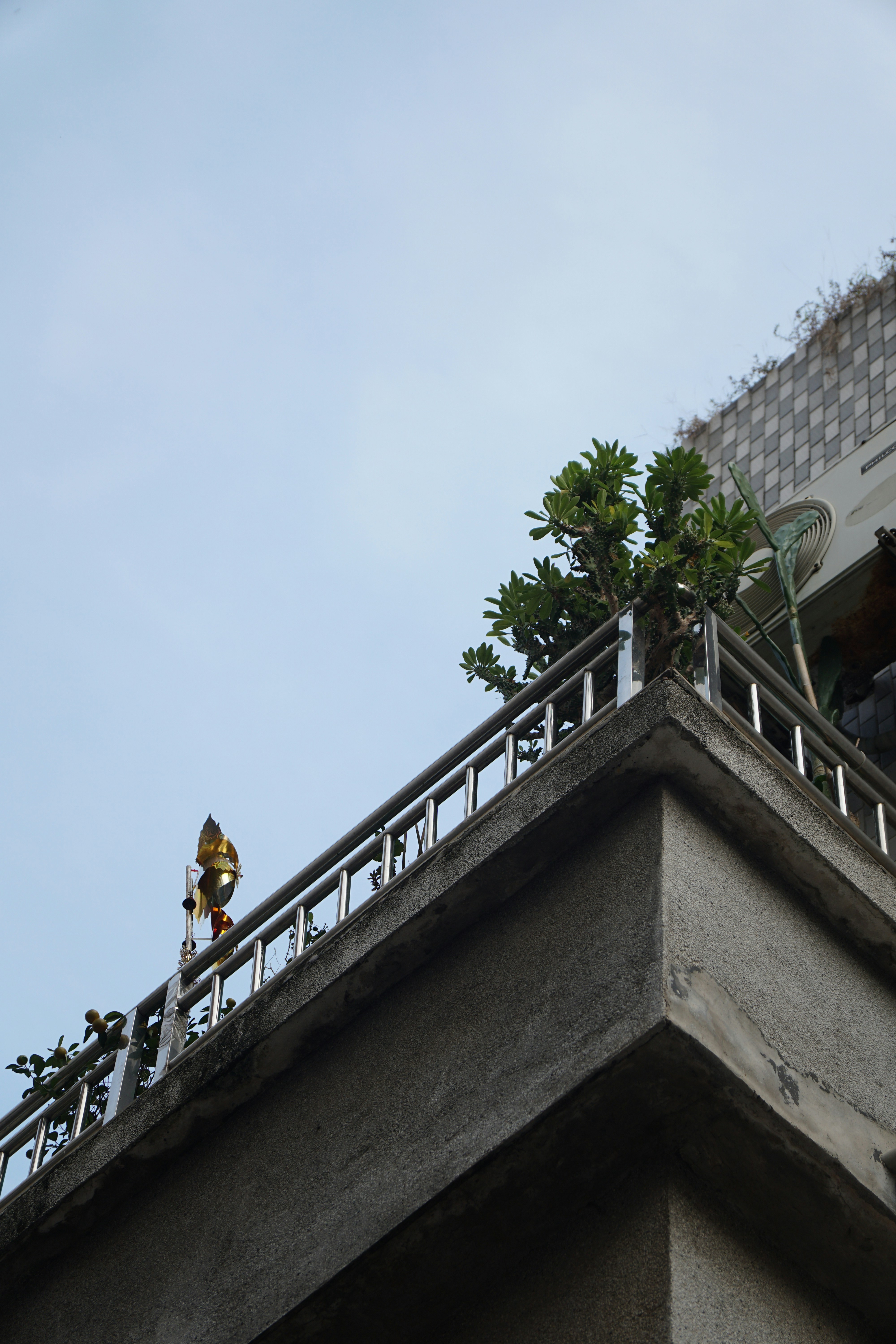 Gold Finial on the Balcony Edge Under a Quiet Blue Sky