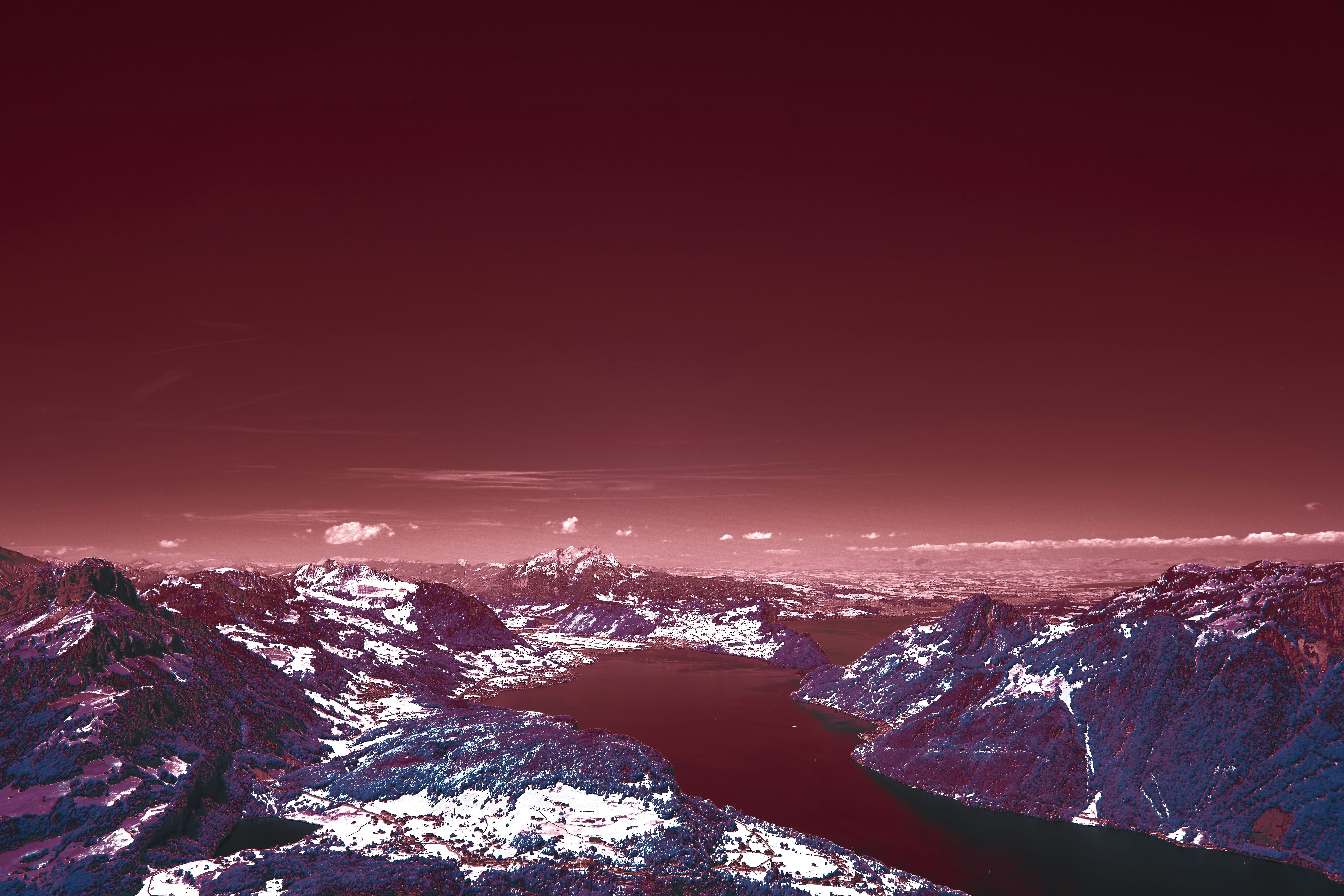 Snowy mountains surround a dark, reflective lake.