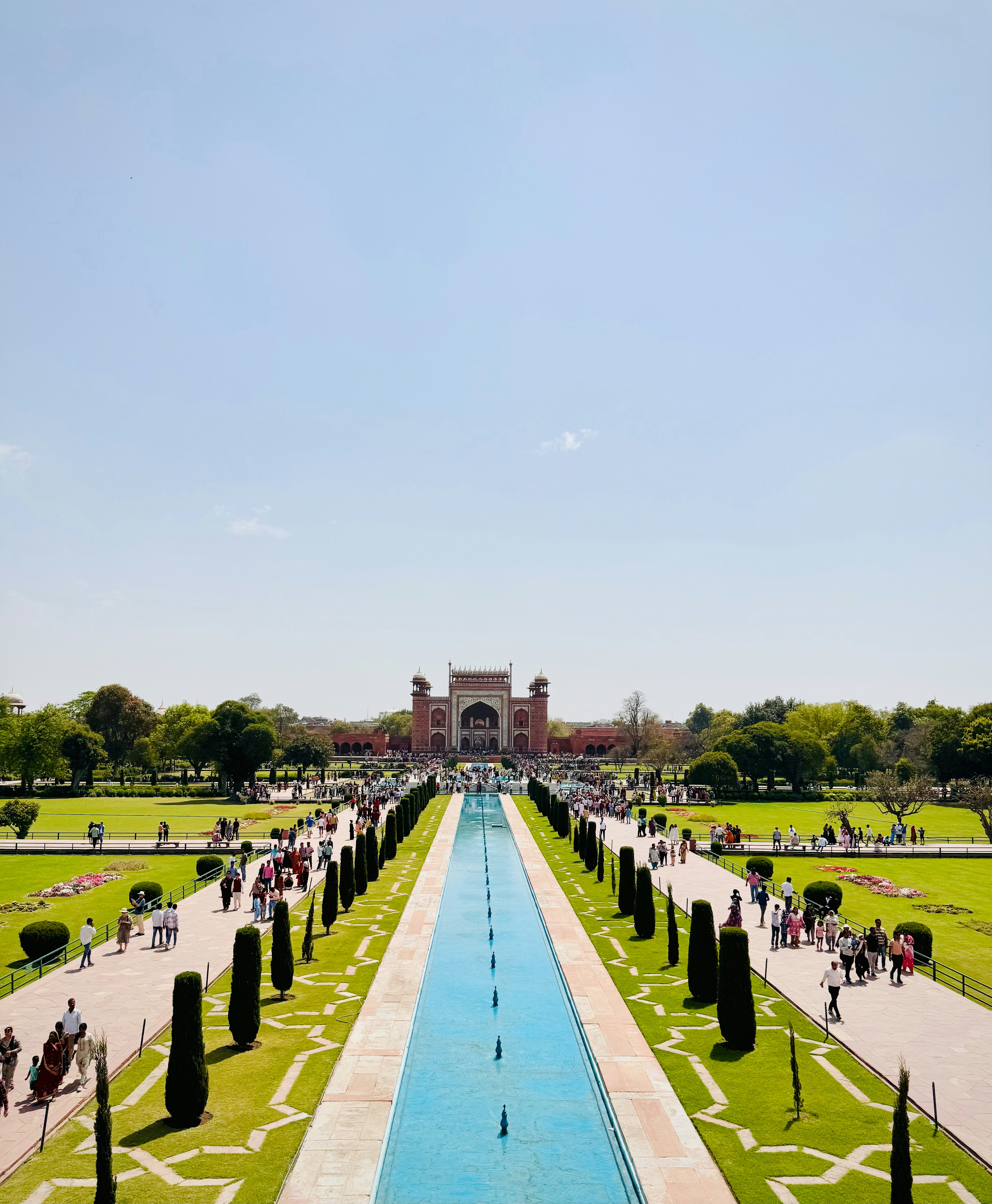 The Taj | People walking in a garden towards a large building.