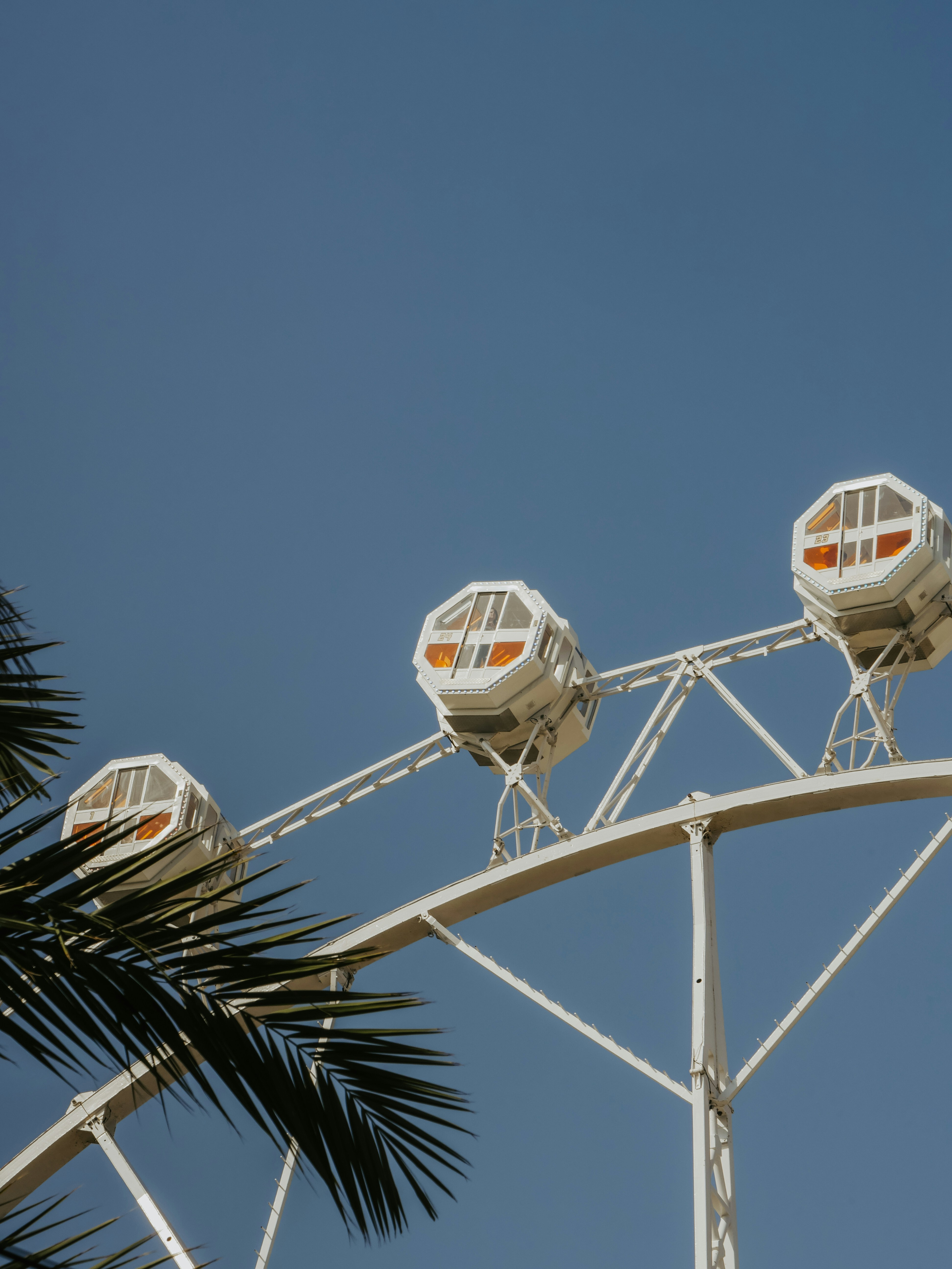 aesthetic ferris wheel | Ferris wheel cabins against a clear blue sky.