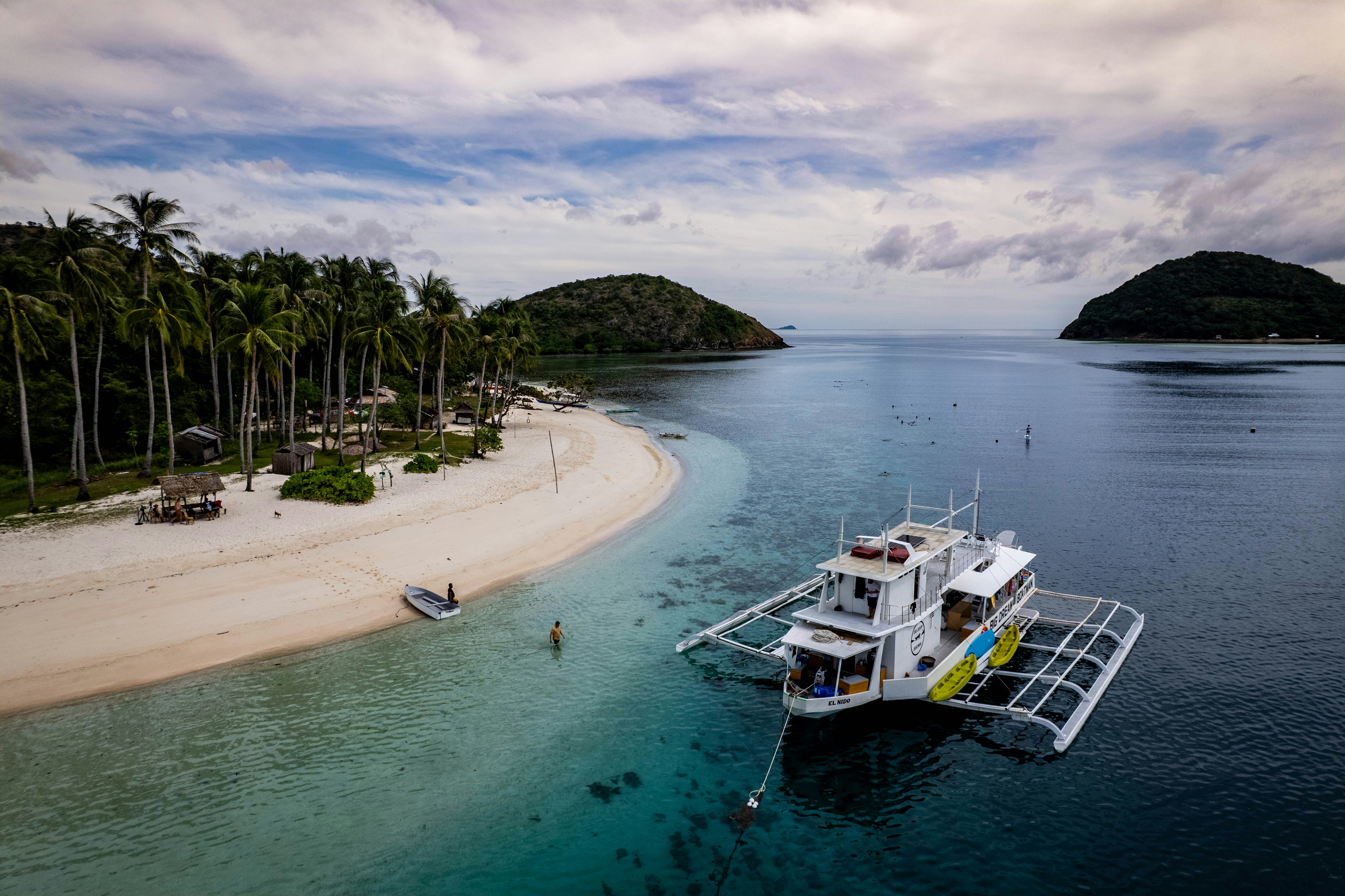 Turquoise Cove Rendezvous: Palm-Lined Shores and a Docked Outrigger