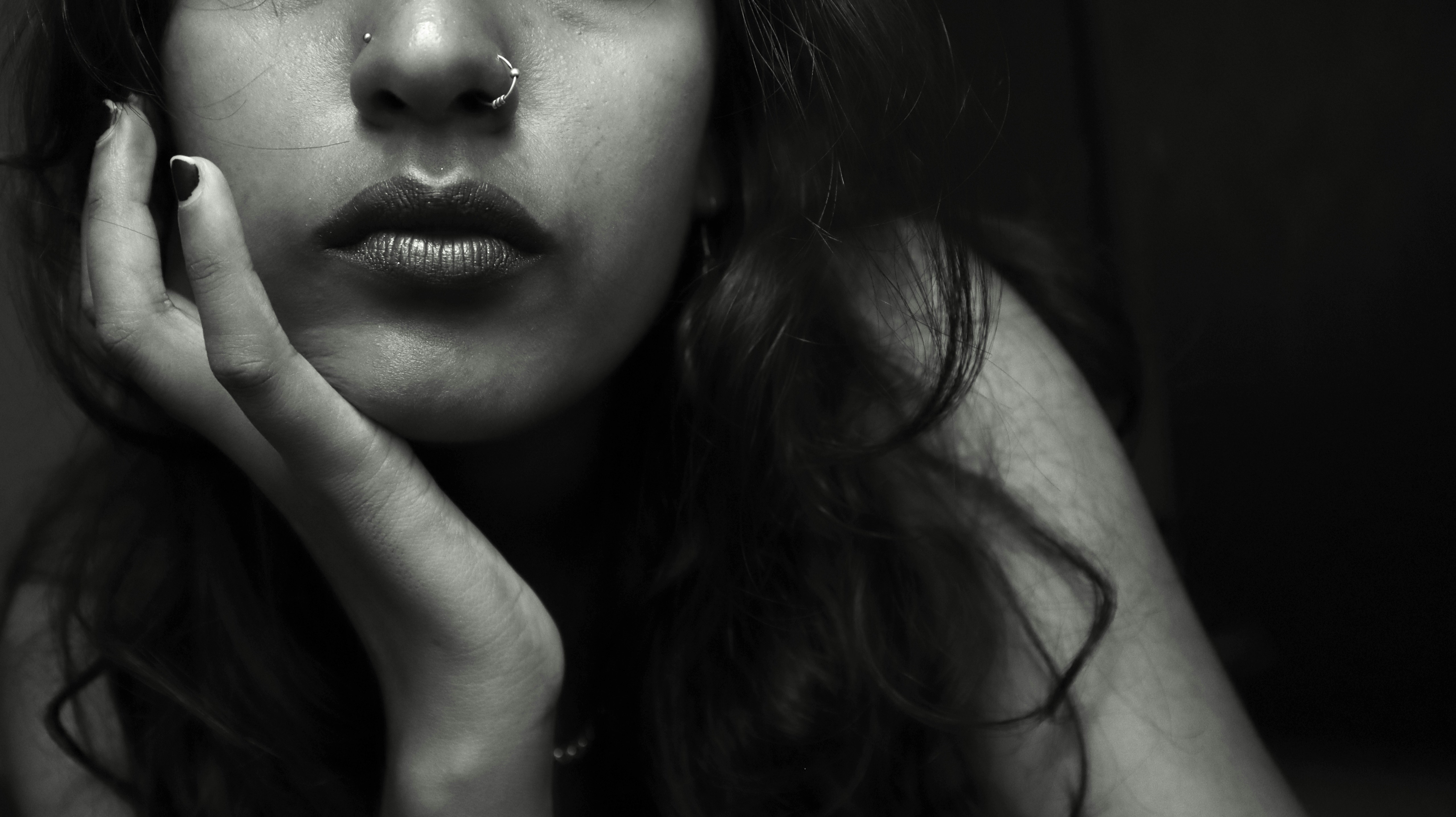Close-up of a woman's face with hand on chin.