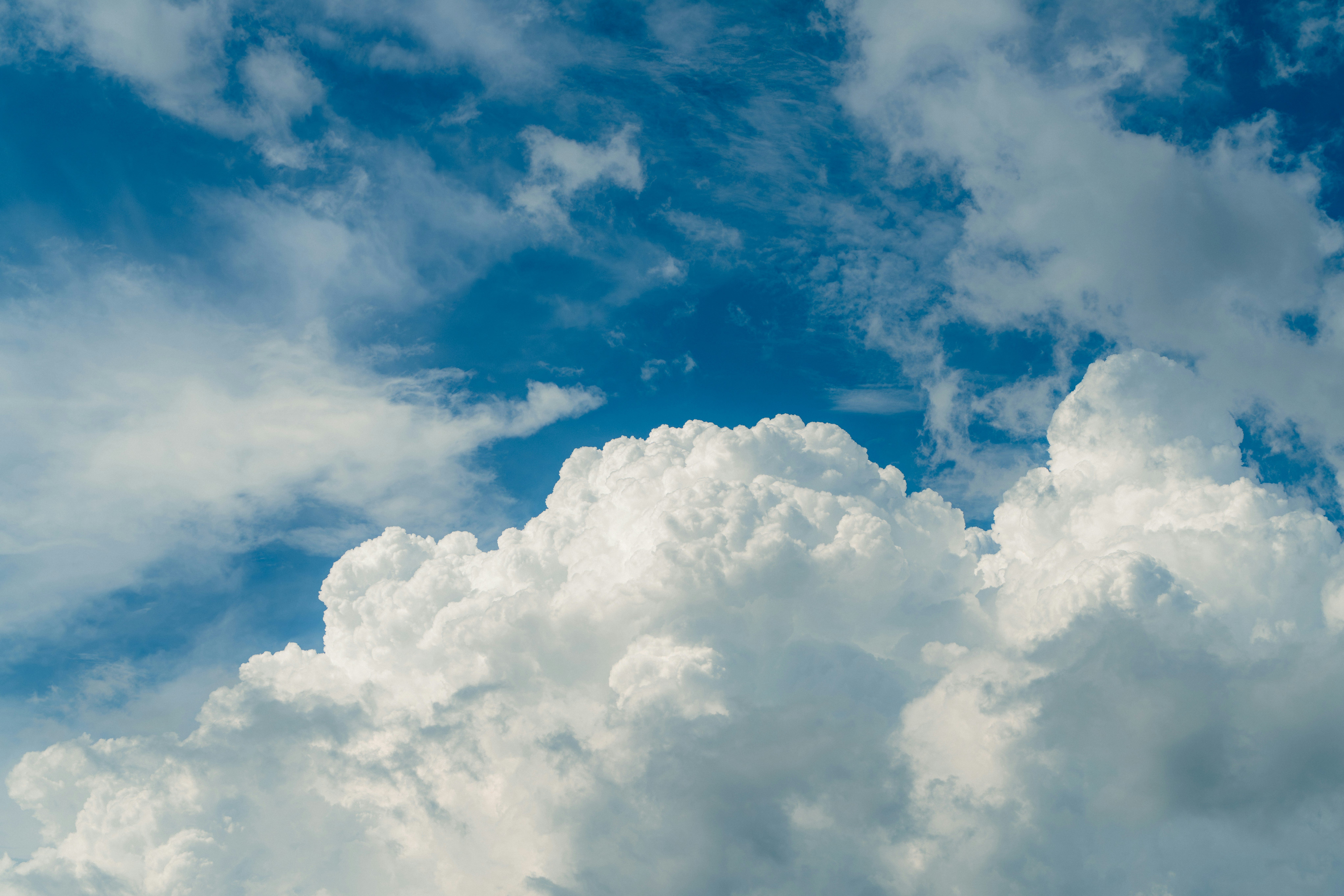 Fluffy white clouds against a bright blue sky