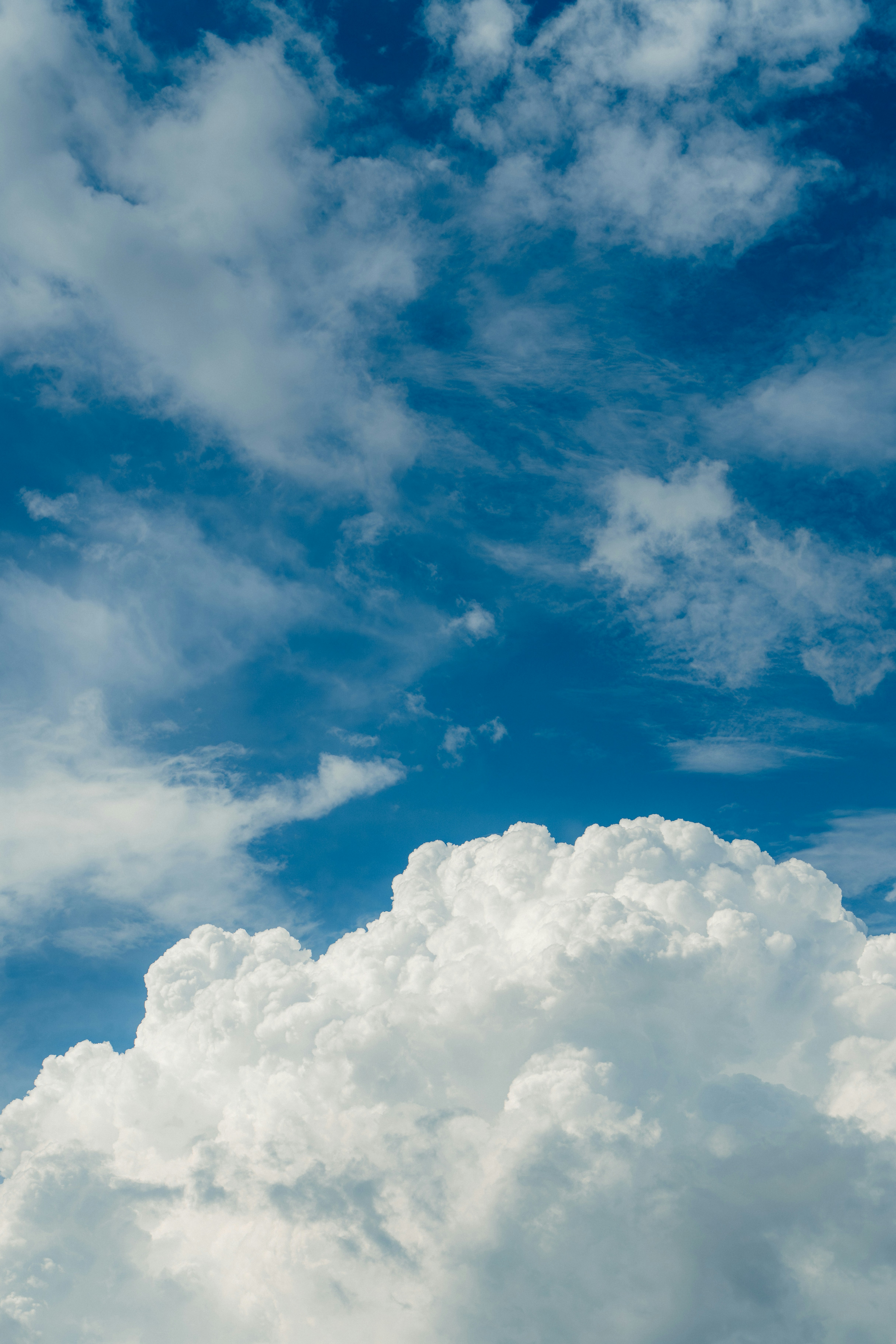 Fluffy white clouds against a bright blue sky