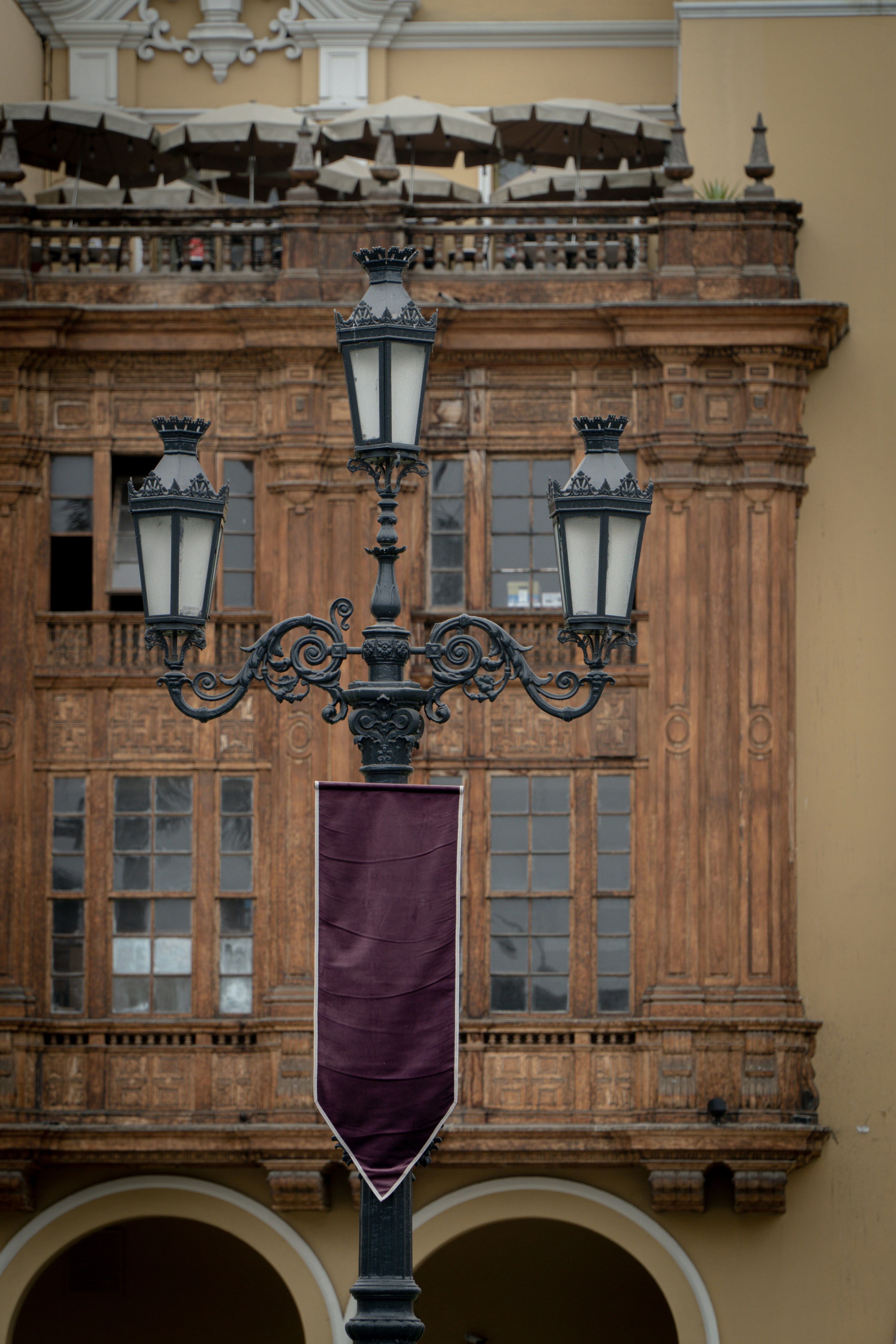 Ornate lamppost in front of a wooden balcony
