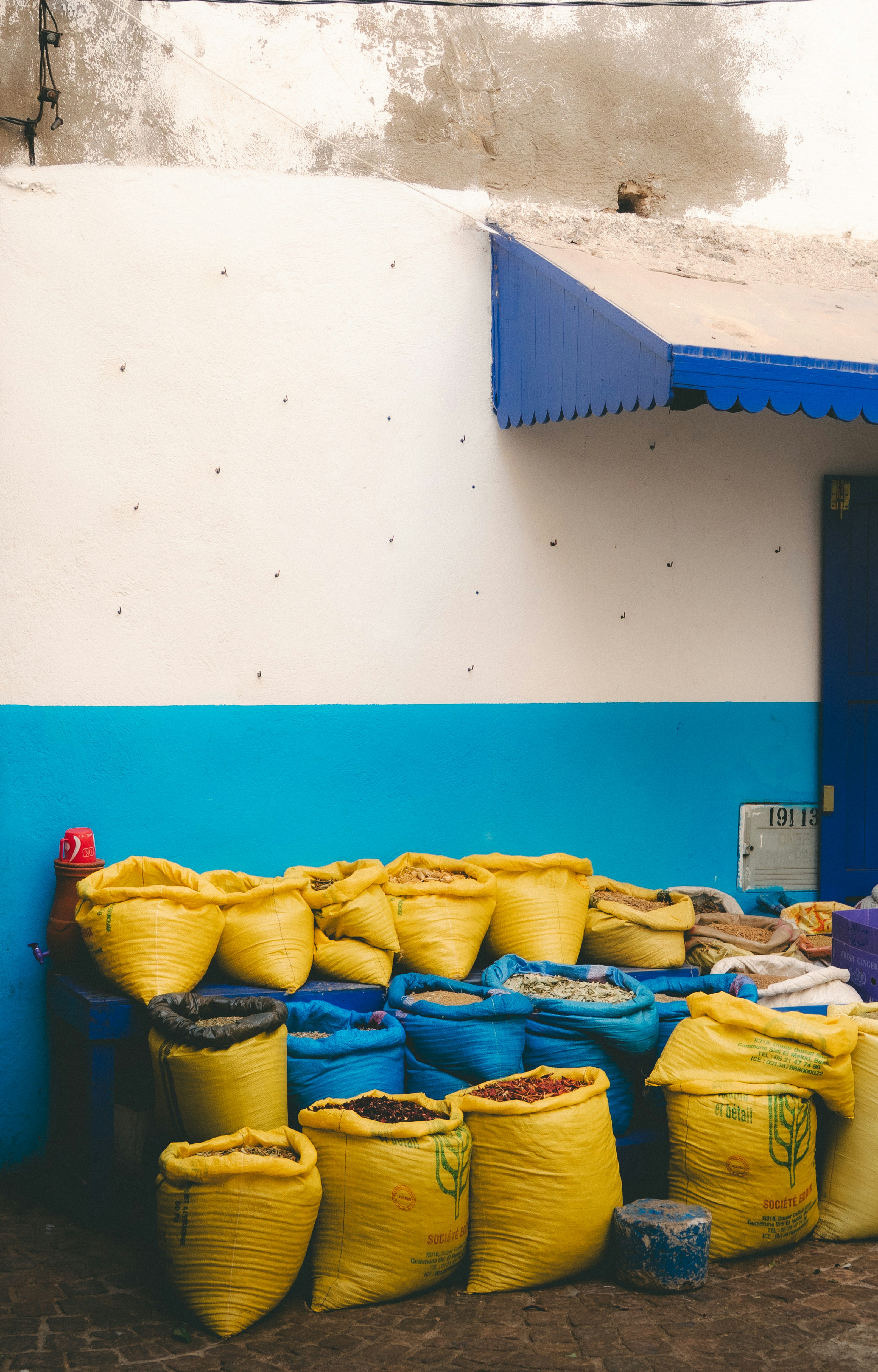 Yellow and blue sacks filled with goods at a market.