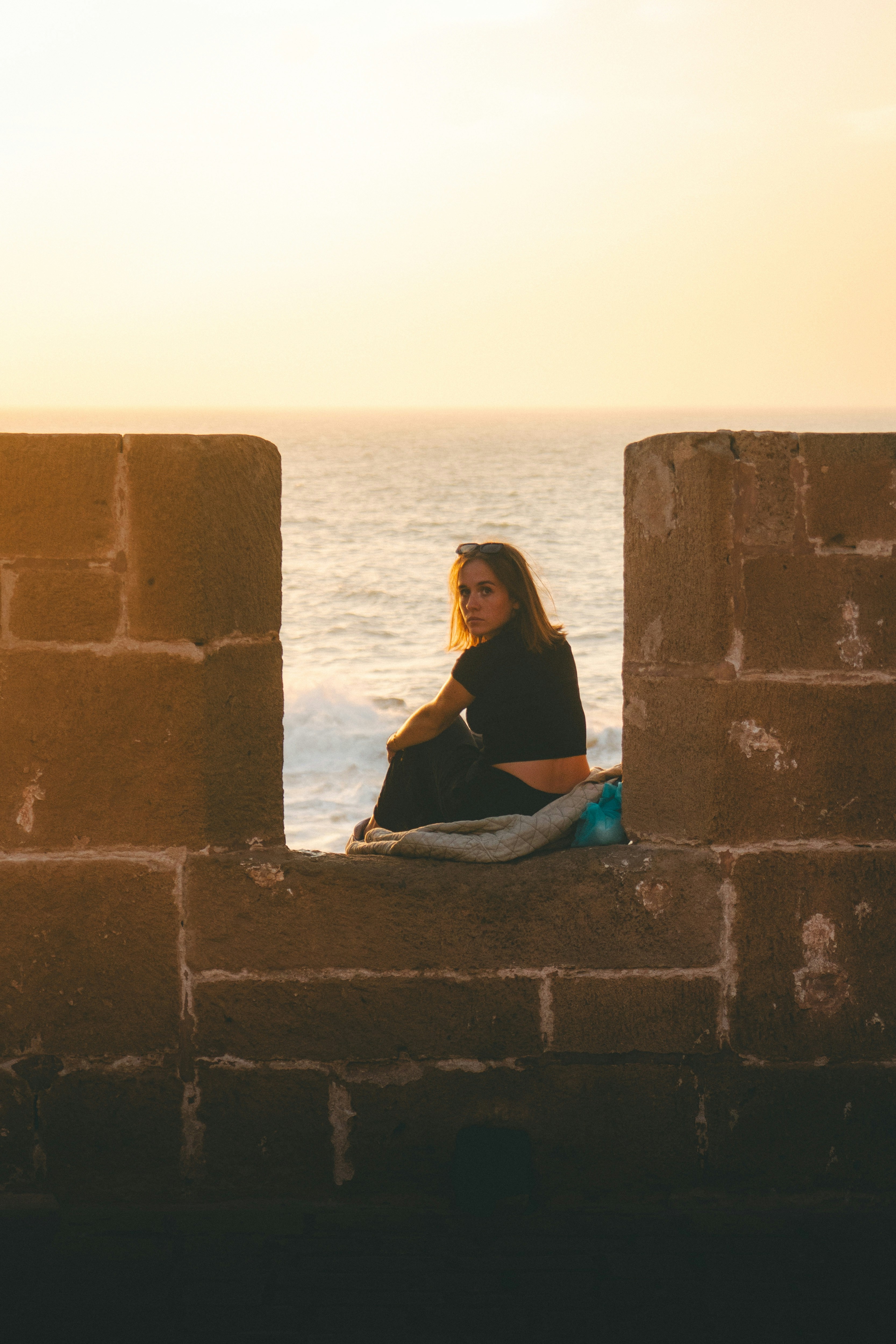 Window to the Sea: A Dusk Portrait Framed by a Weathered Seawall