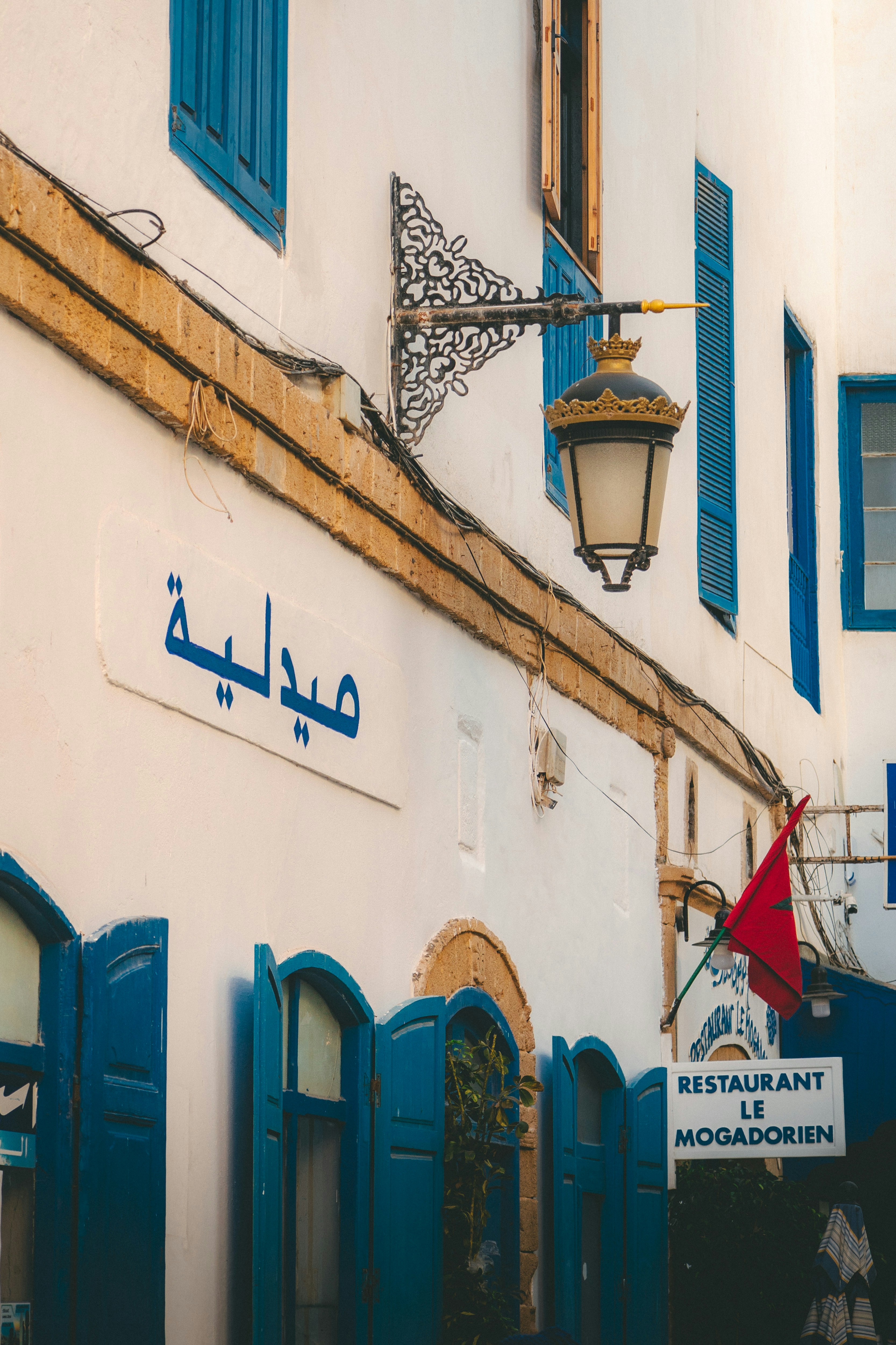 Lantern Over Blue Doors on a White Medina Facade