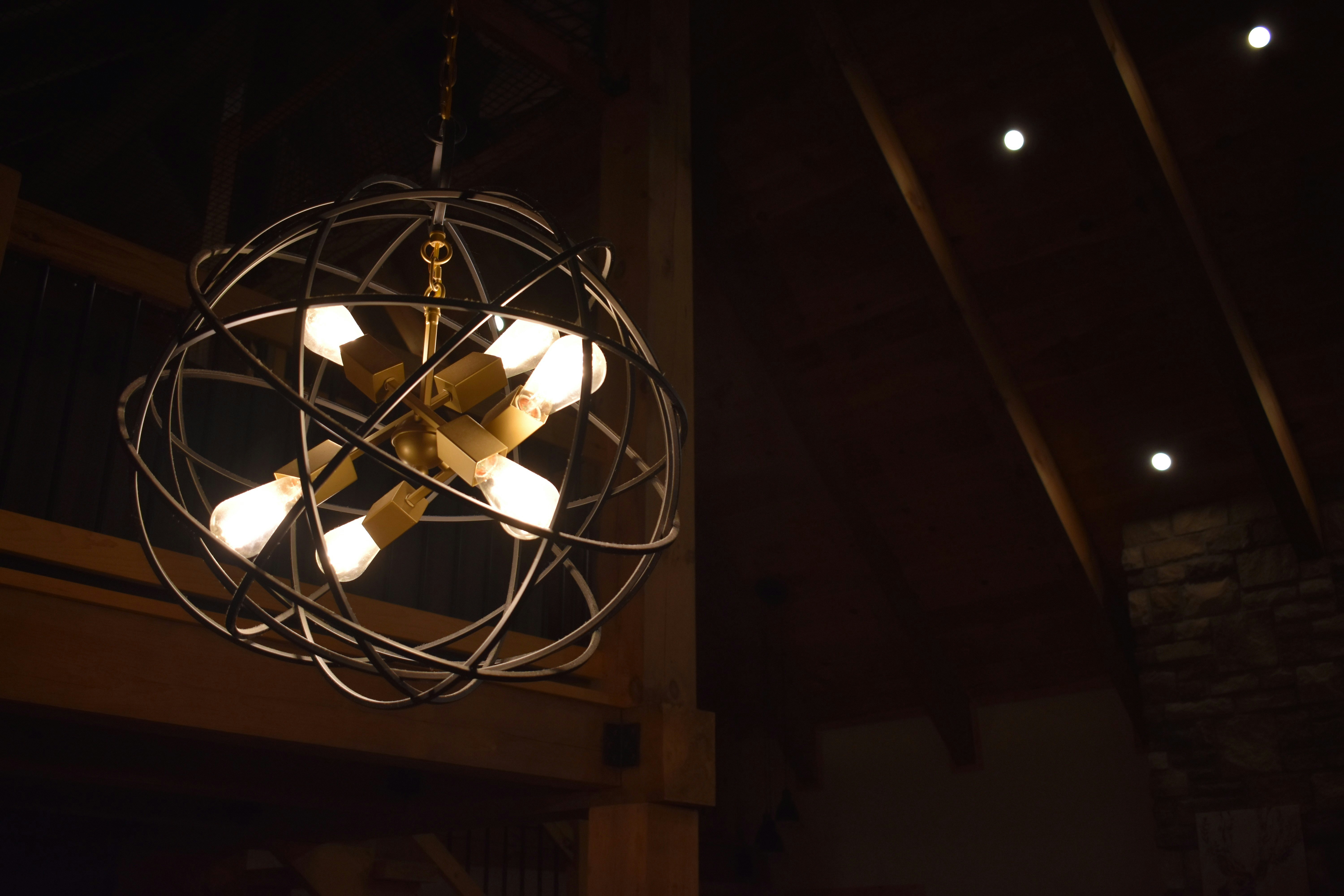 A spherical metal chandelier with exposed bulbs.