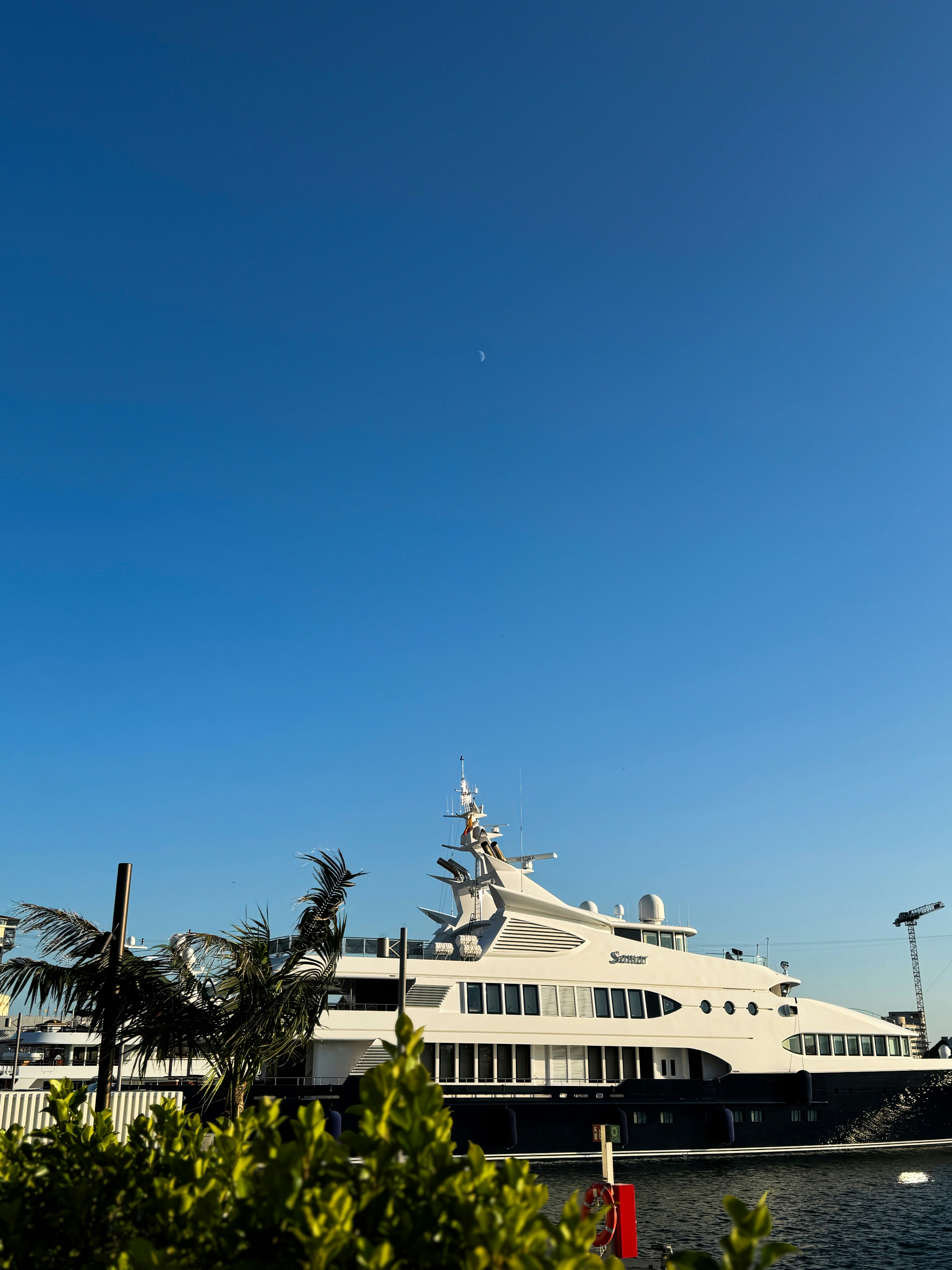 Yachts ready for a voyage | A large white yacht docked under a clear blue sky.