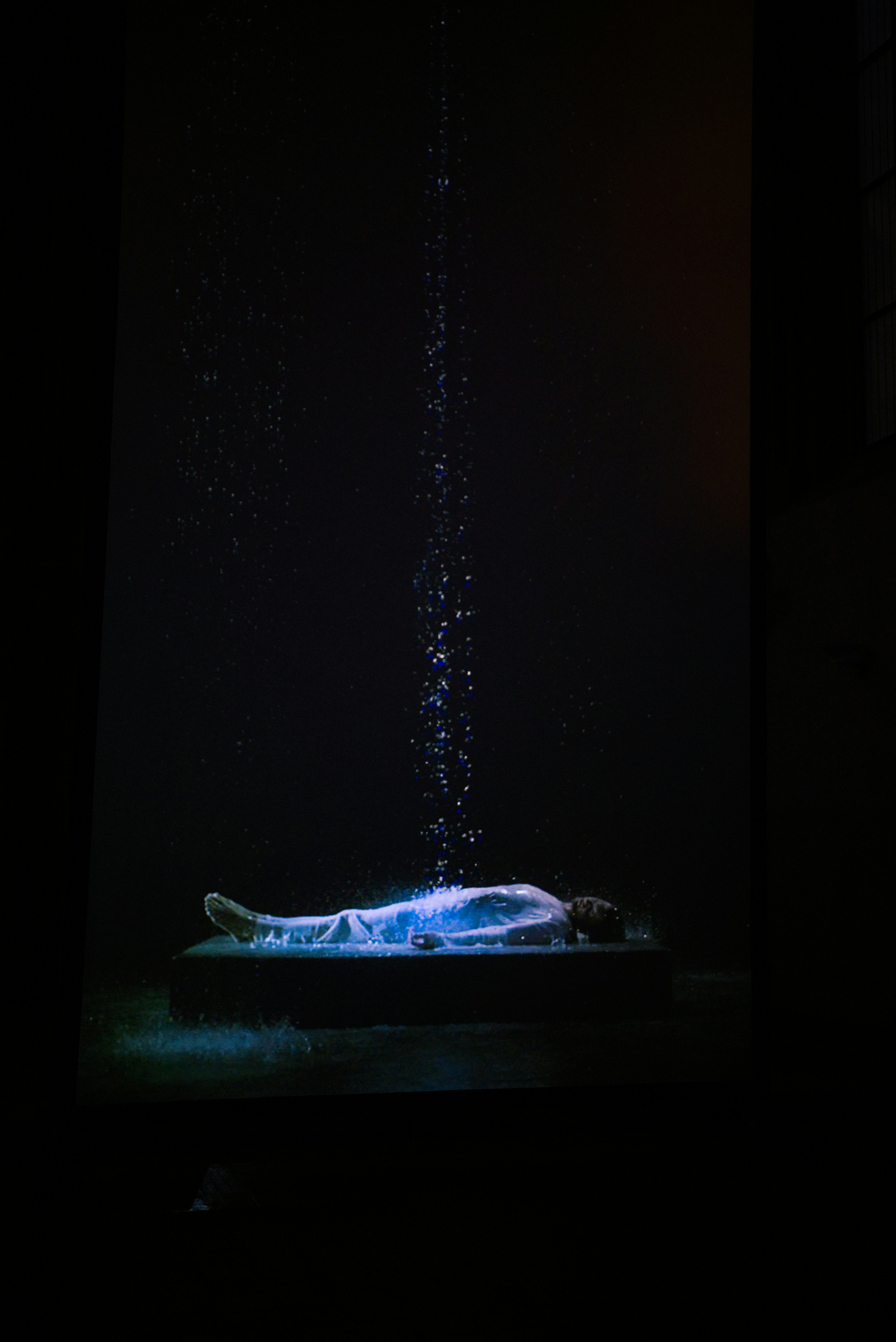 woman | Person lying down with bubbles rising in dark water
