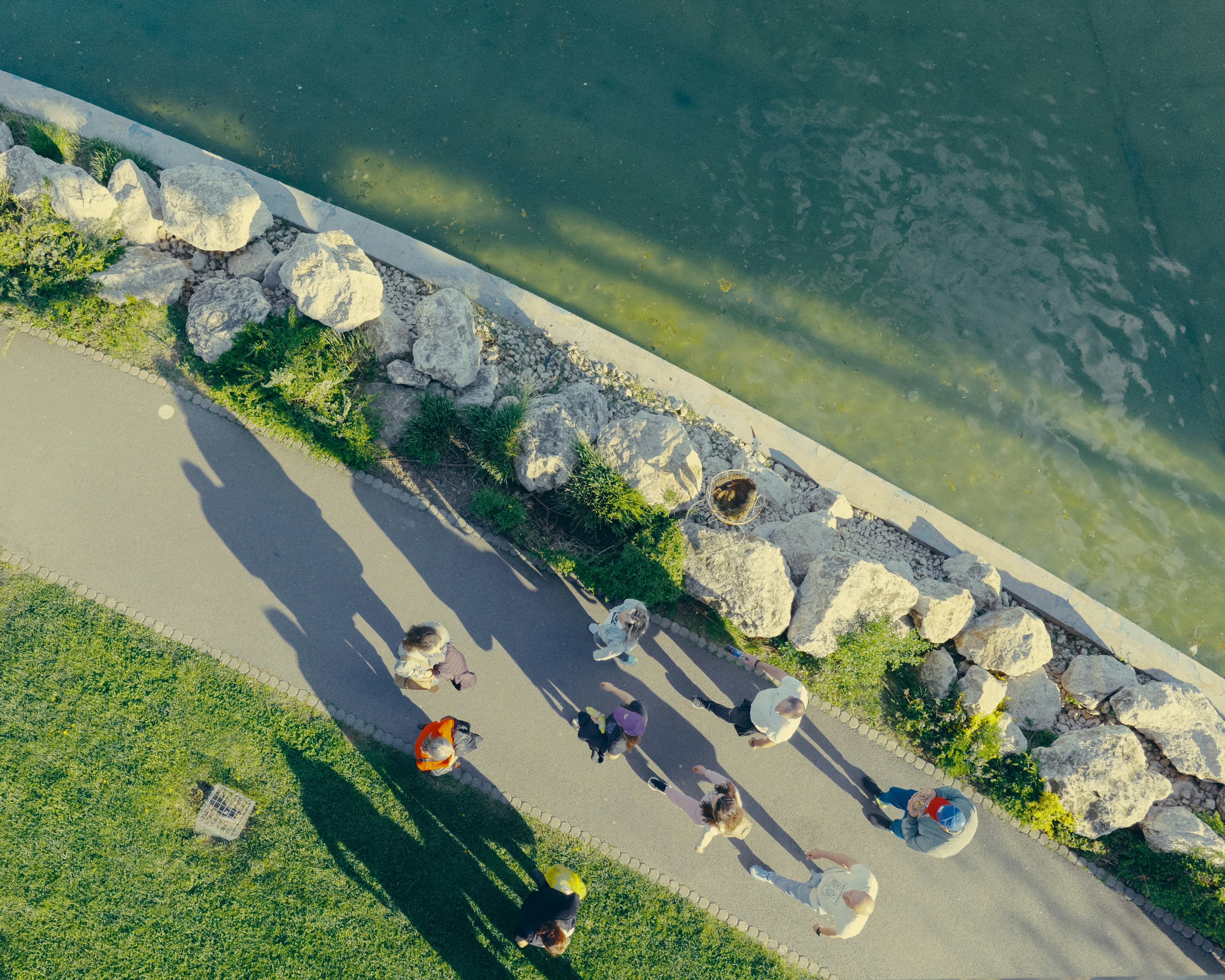People walking on a path by the water