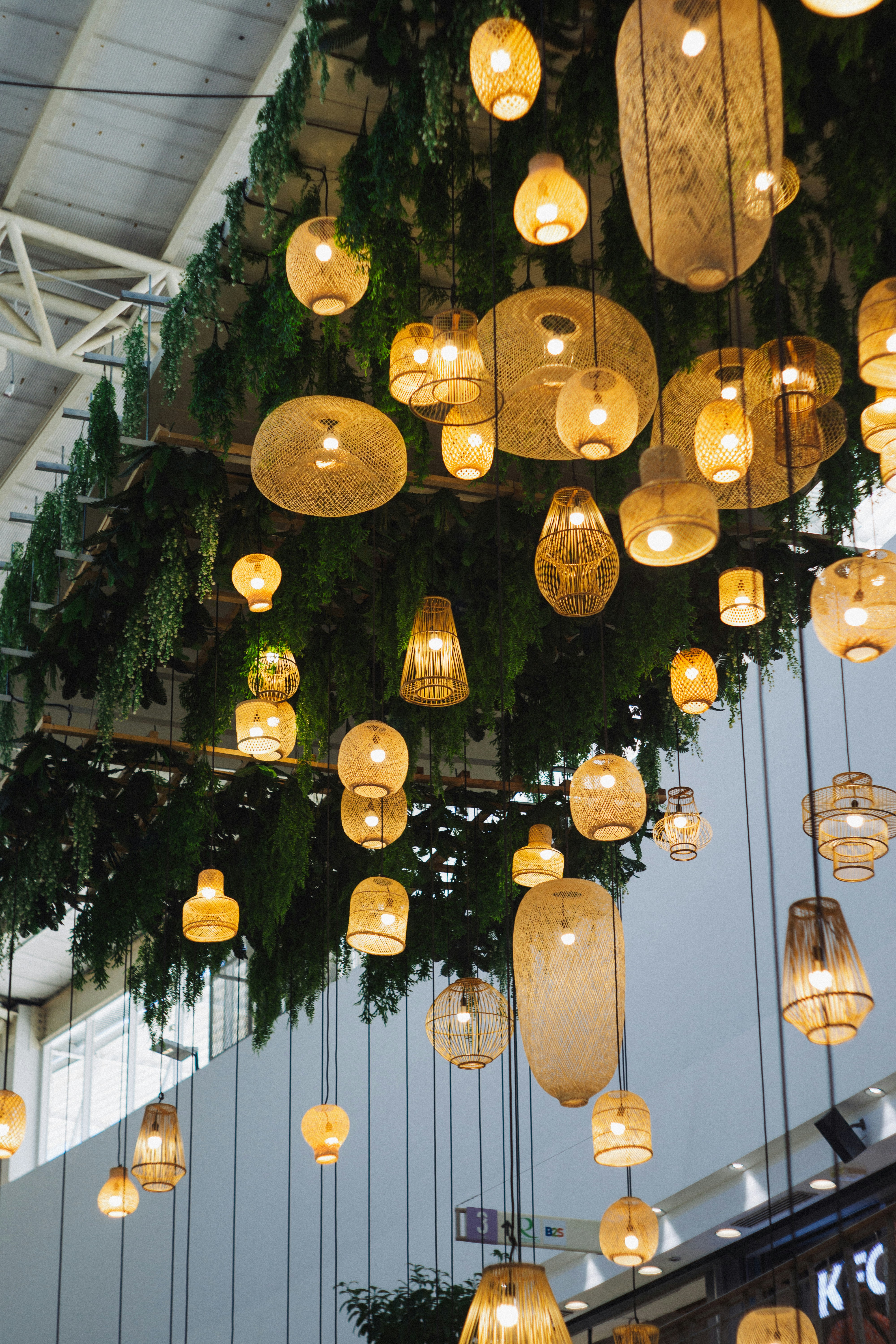 Midair Lantern Garden: Canopy of Warm Orbs Over a Green Atrium