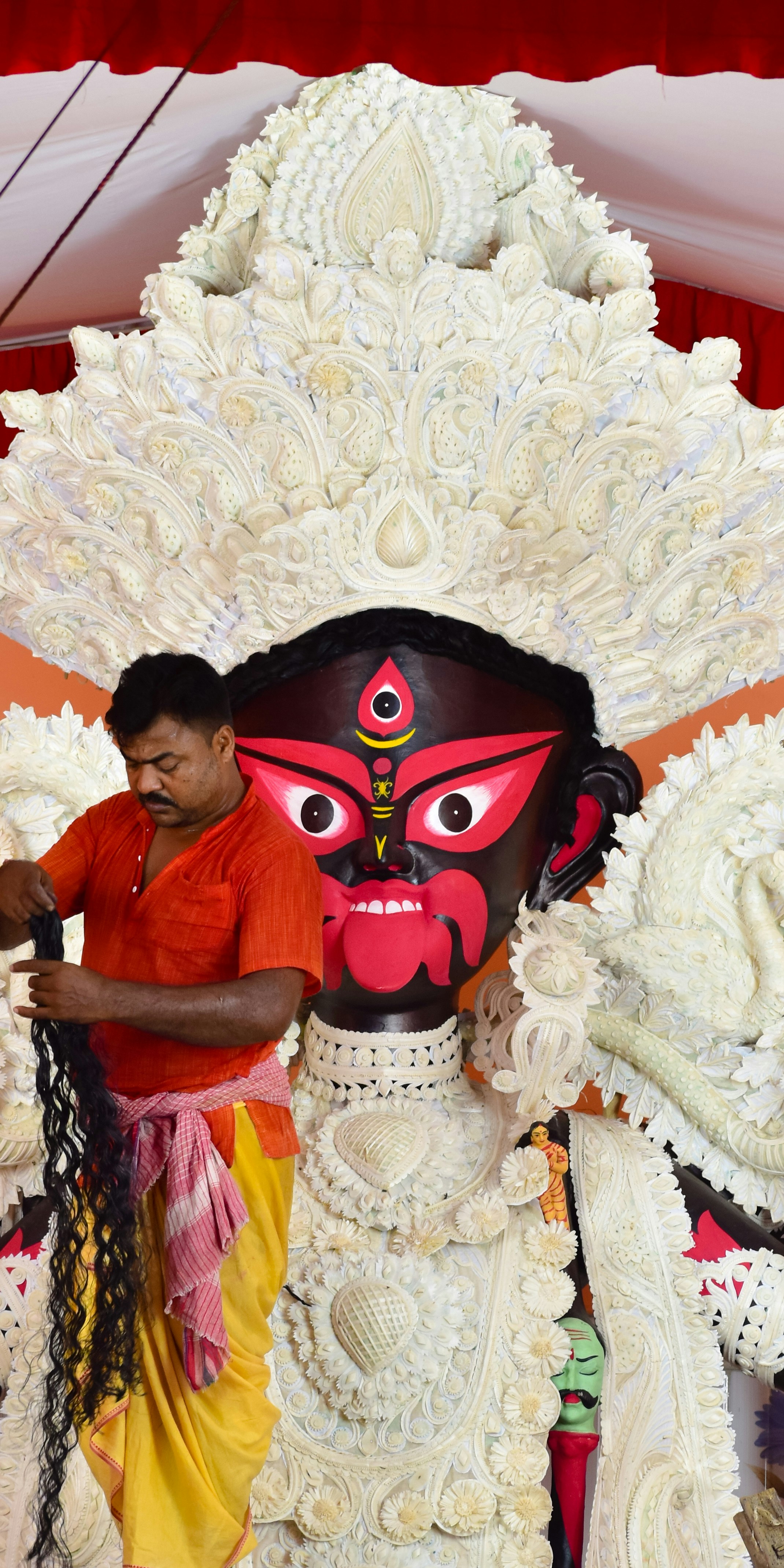 Ivory Throne, Crimson Gaze: A Craftsman Beside an Ornate Festival Mask