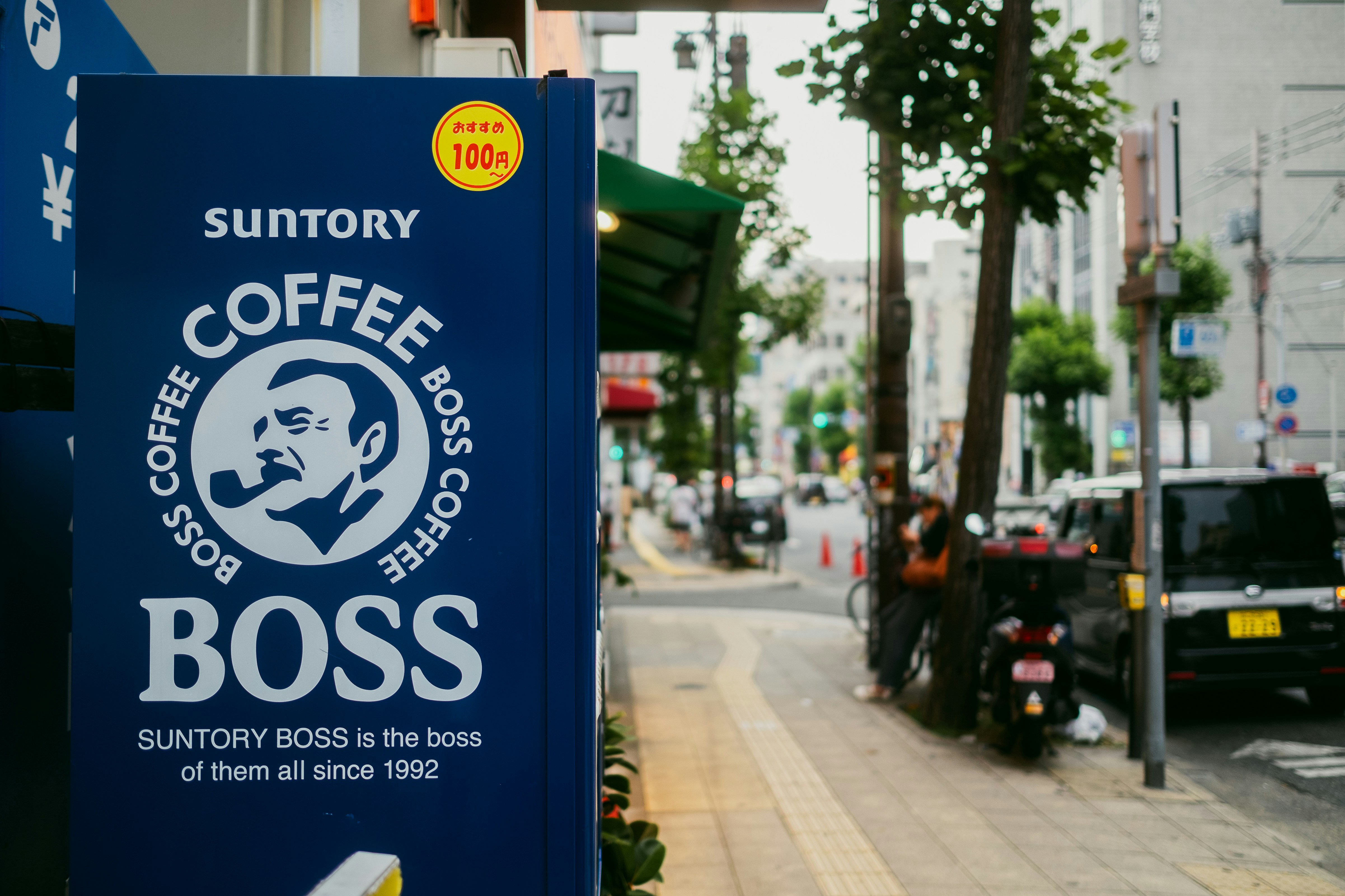 Suntory boss coffee sign on a city street.
