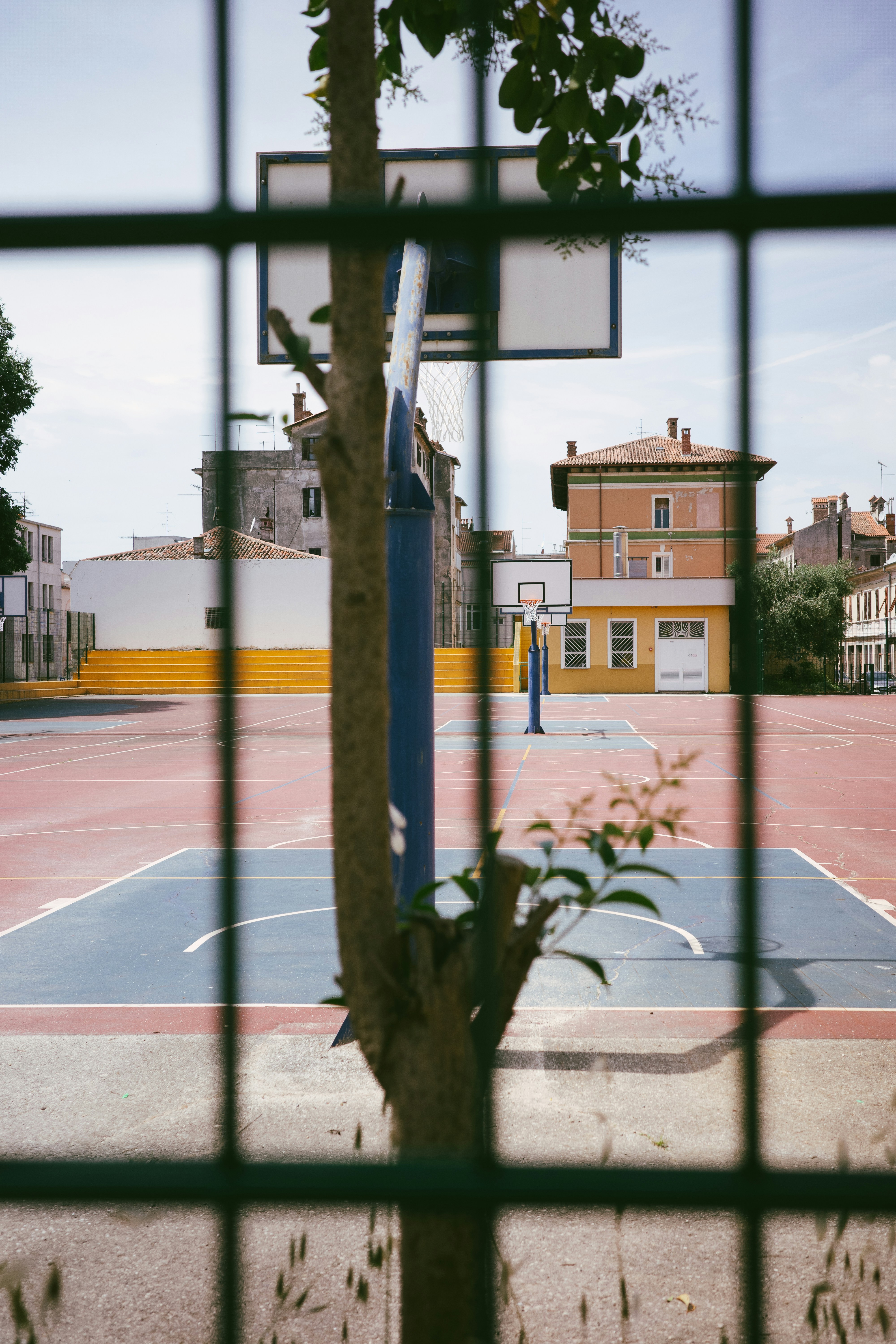 Outdoor basketball court behind a fence