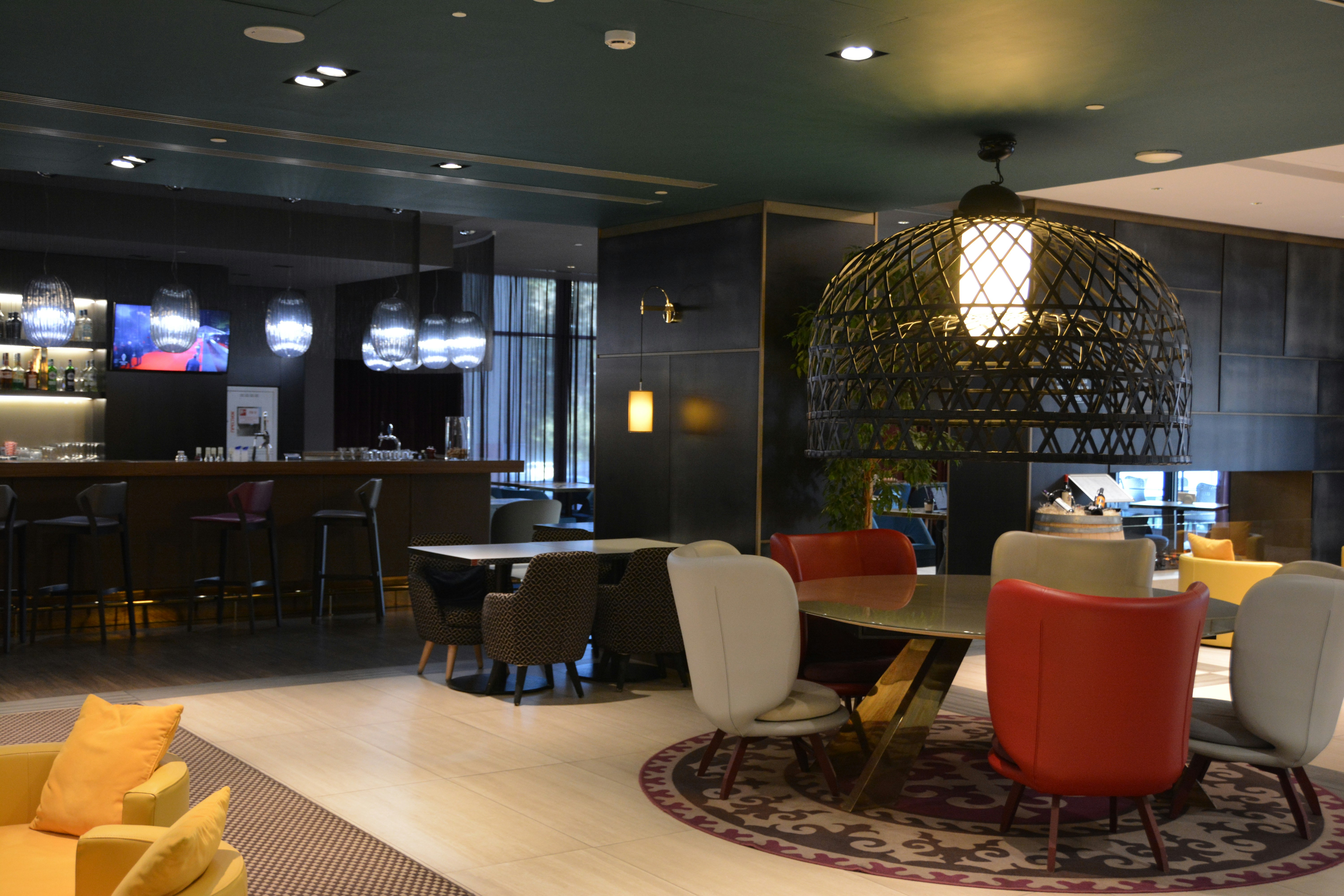 Modern lounge area with bar and colorful seating.