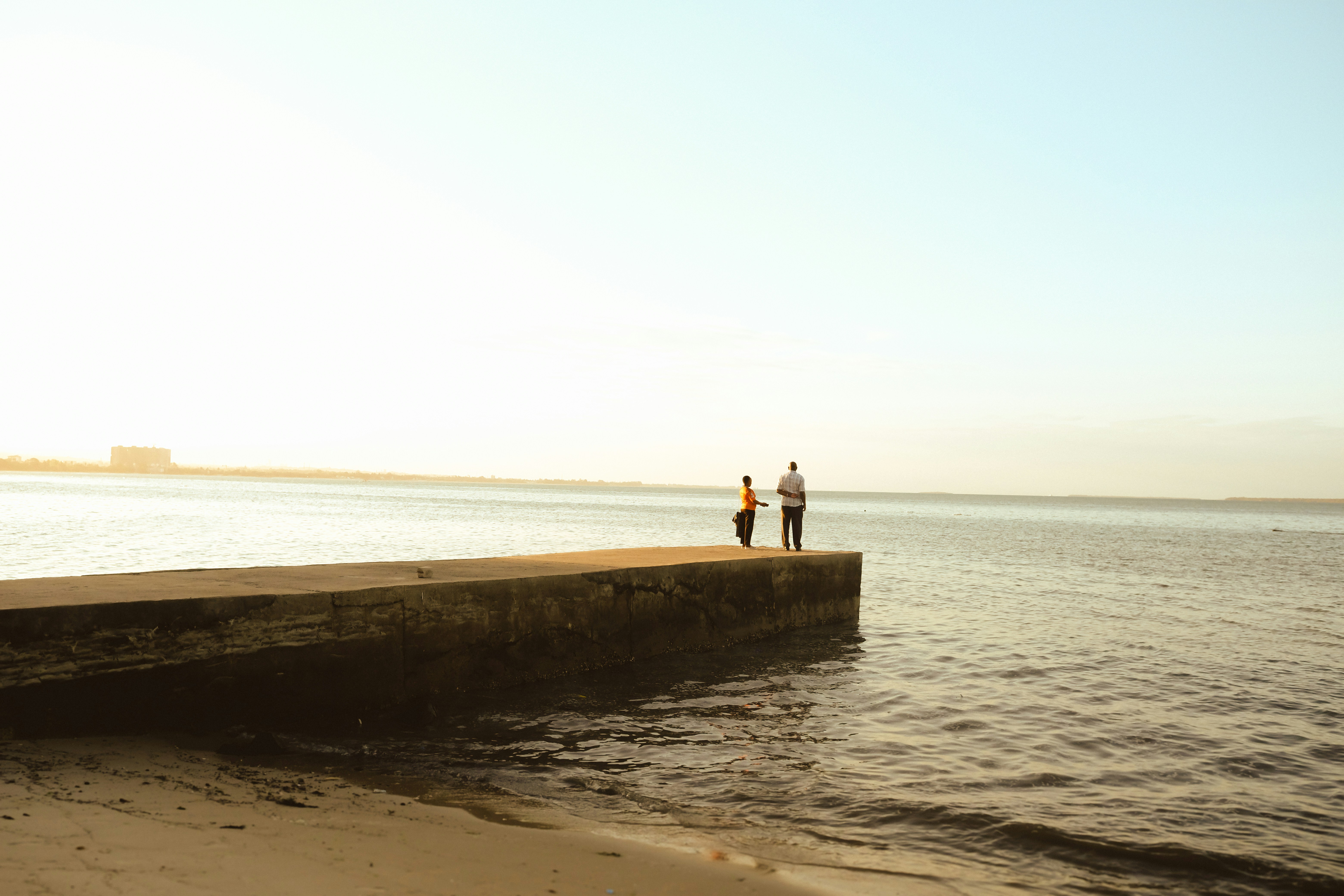 Dusk at the Pier: Two Silhouettes at the End of the Jetty