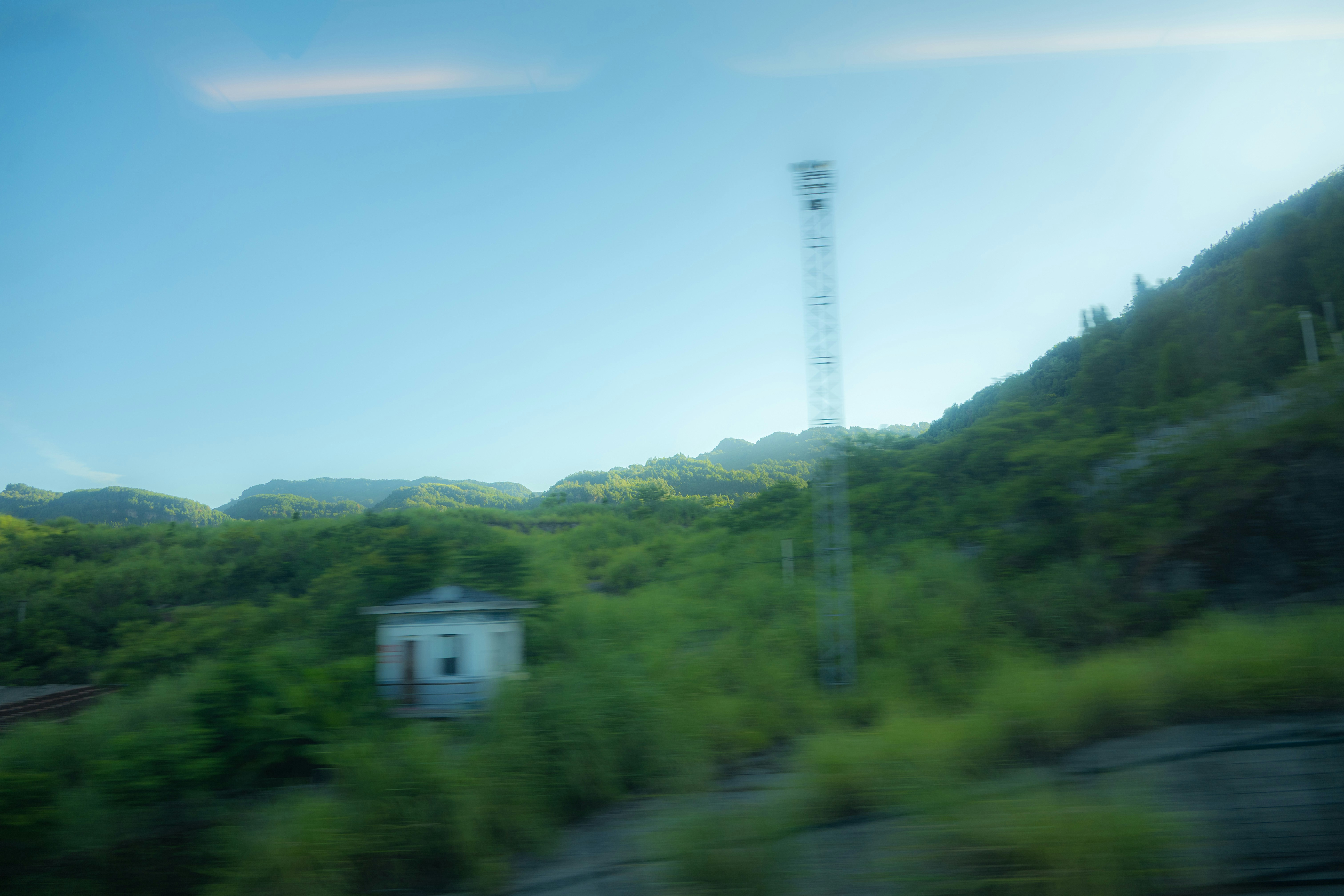 Small building and tower on a green hillside