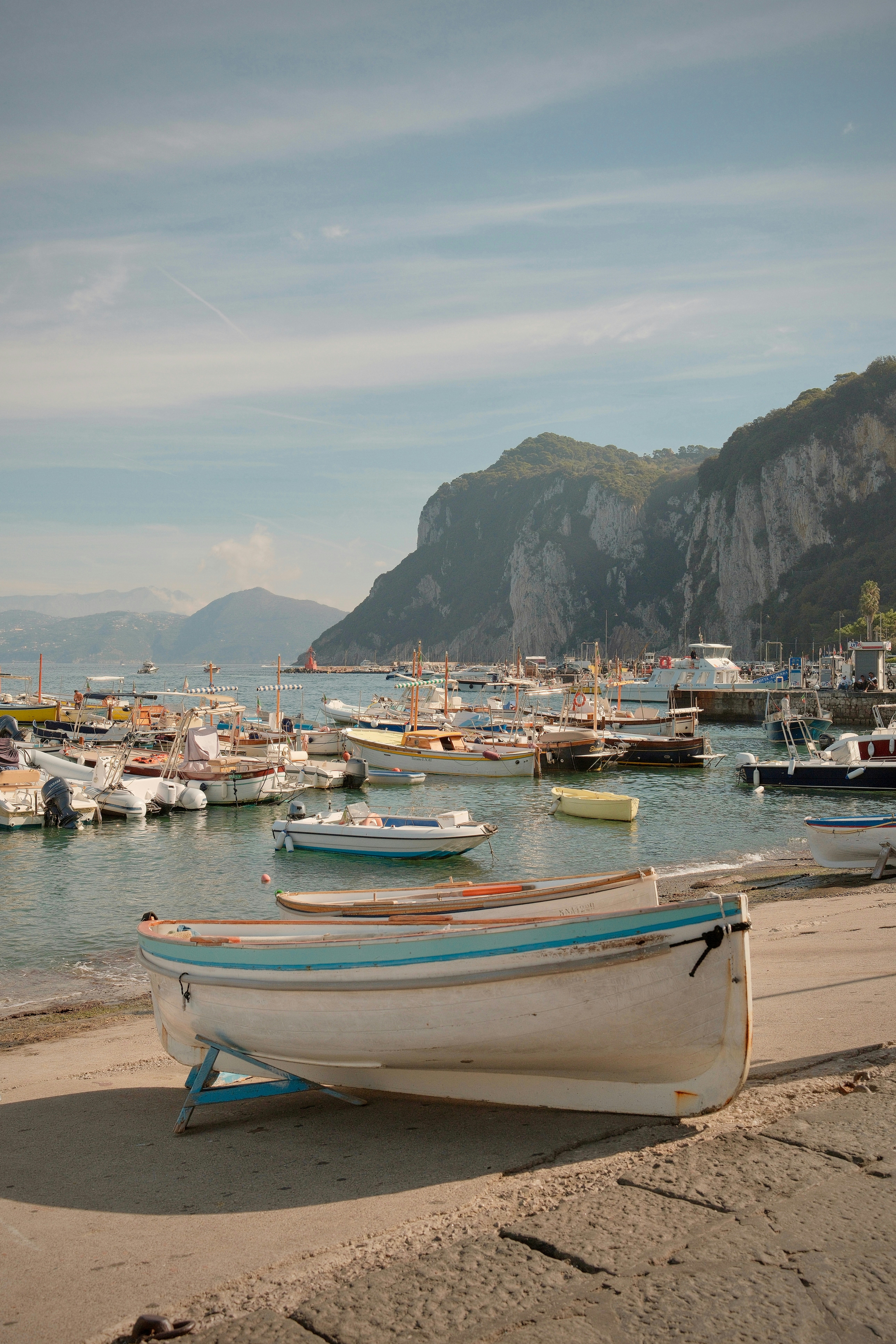 Boats docked in a harbor with mountains in background