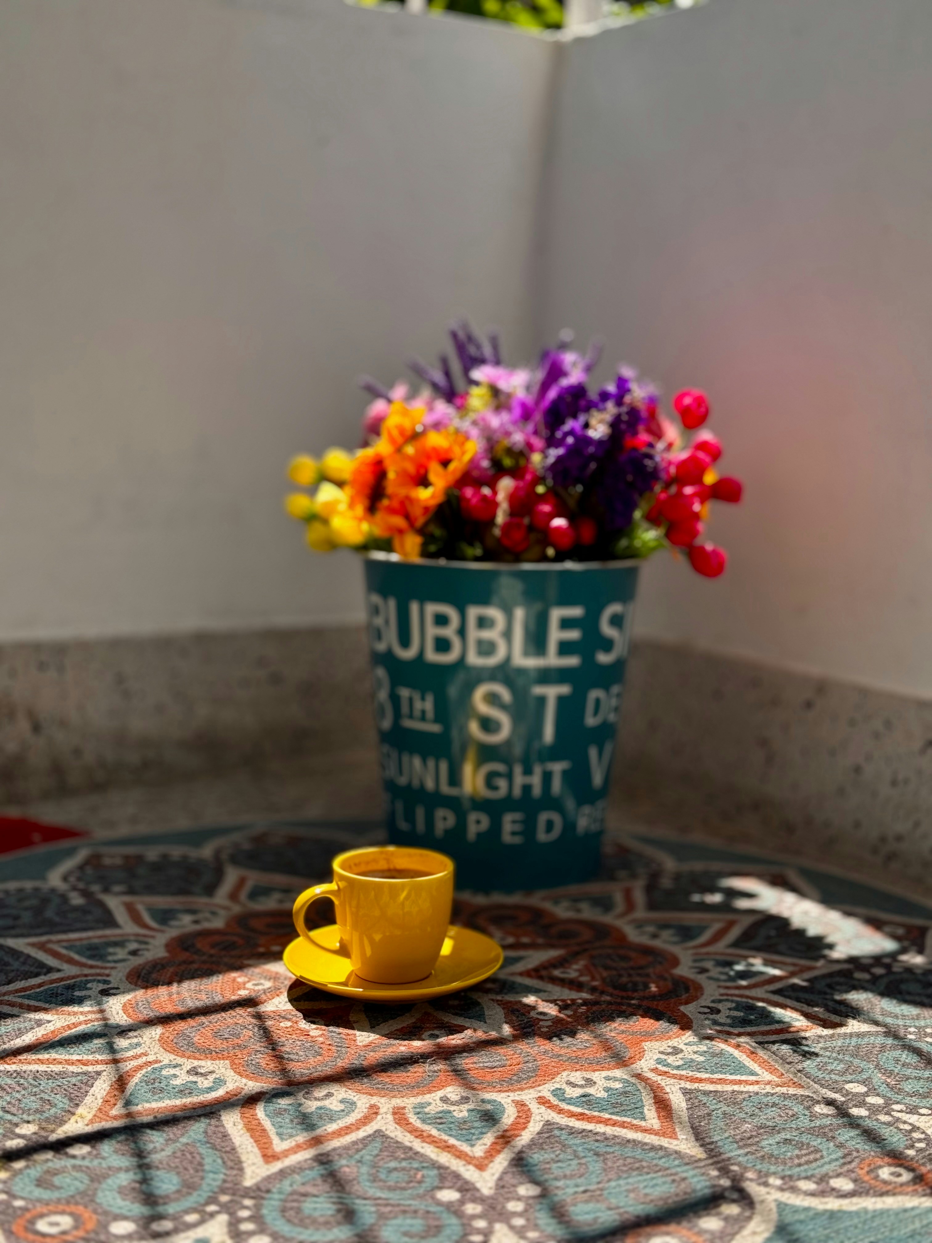 Yellow teacup and saucer with colorful flowers