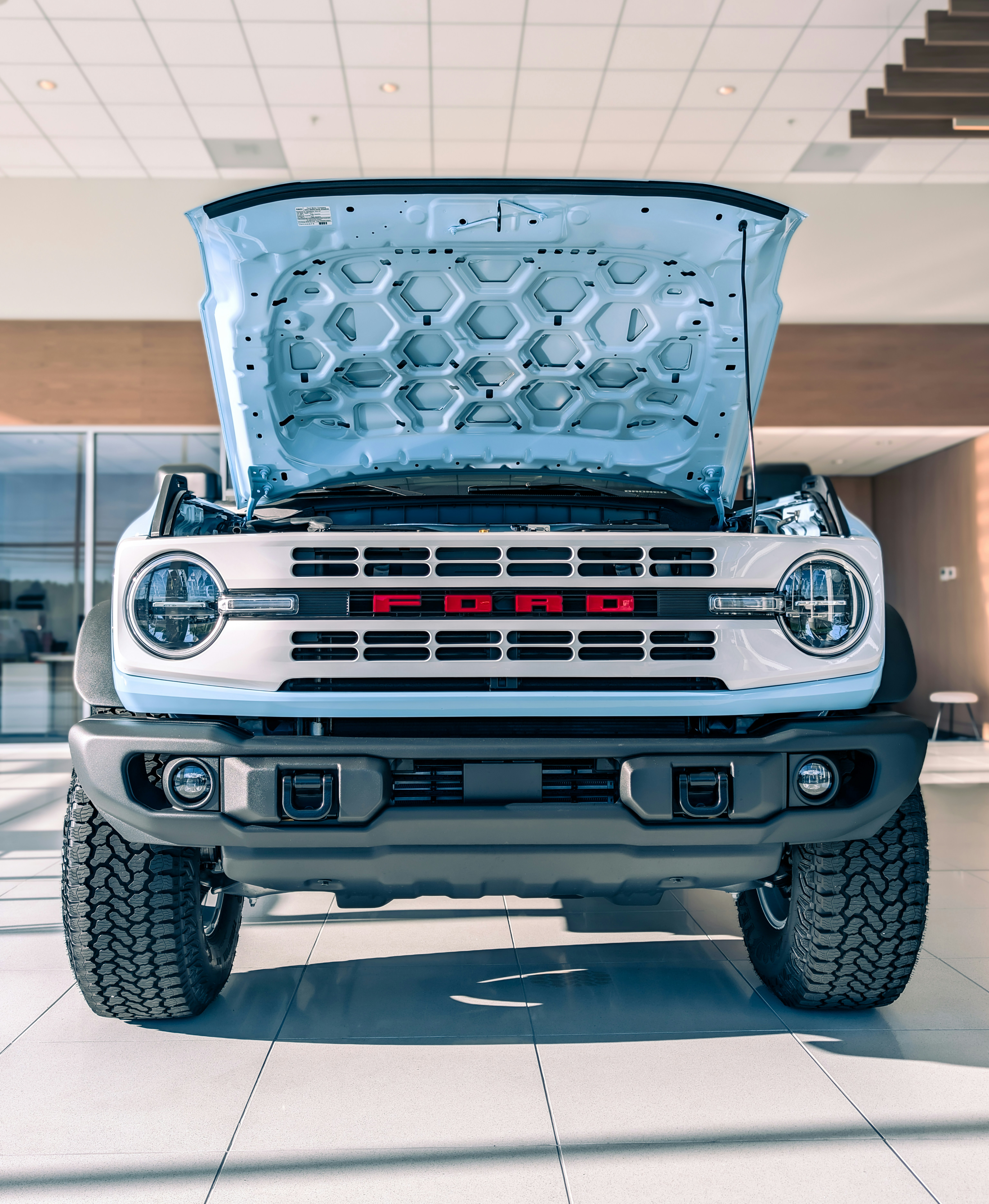 A breathtaking vision of automotive perfection! This light blue Bronco beautifully marries iconic retro design with untamed, modern power, promising incredible adventures just beyond the showroom floor. A captivating vehicle!