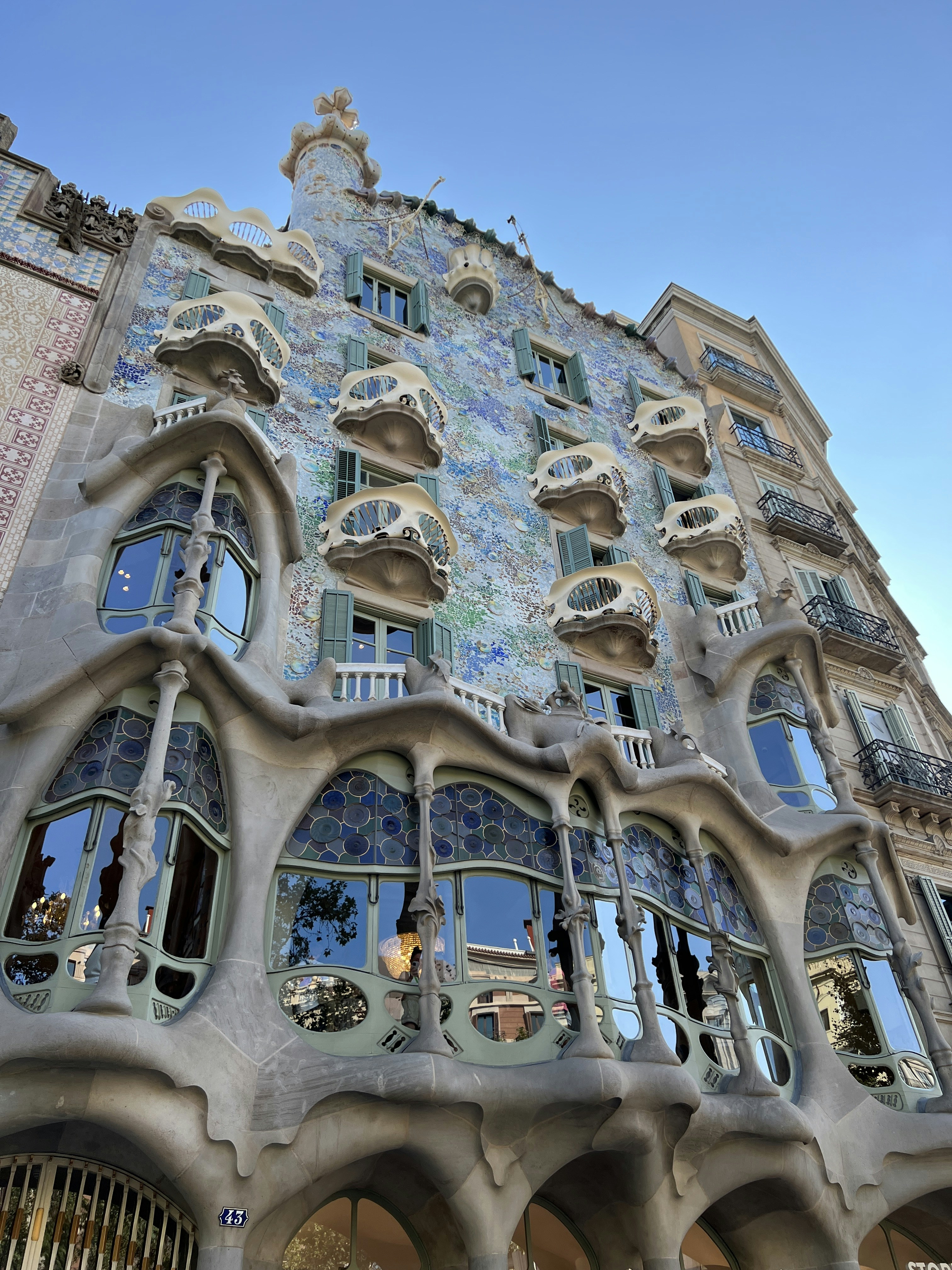 This iconic building in Barcelona's Paseo Gracia boasts a stunning façade with intricate details and a prominent clock tower, embodying the city's rich architectural heritage.