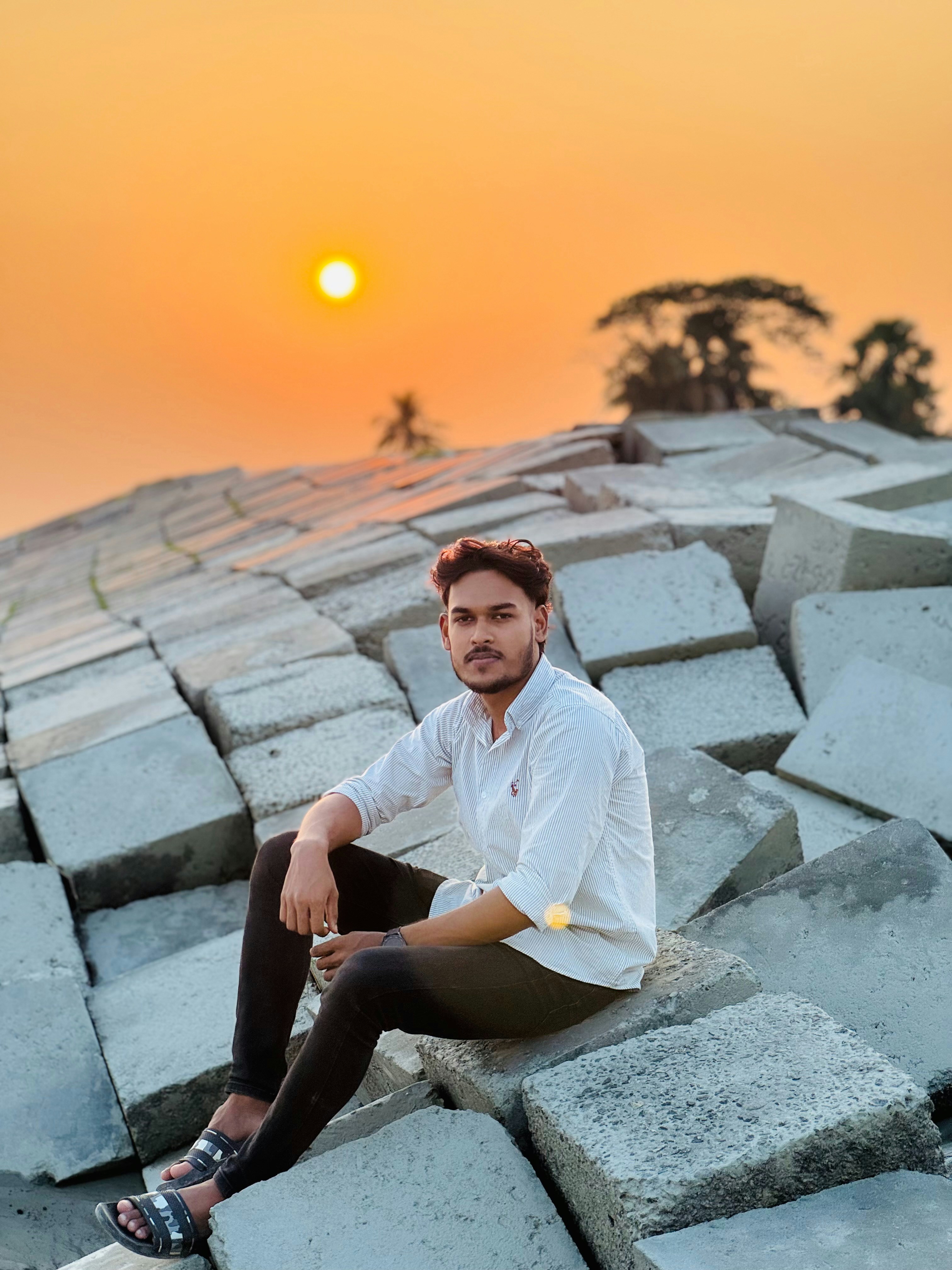 Chasing sunsets and peace of mind. | Man sitting on concrete blocks at sunset