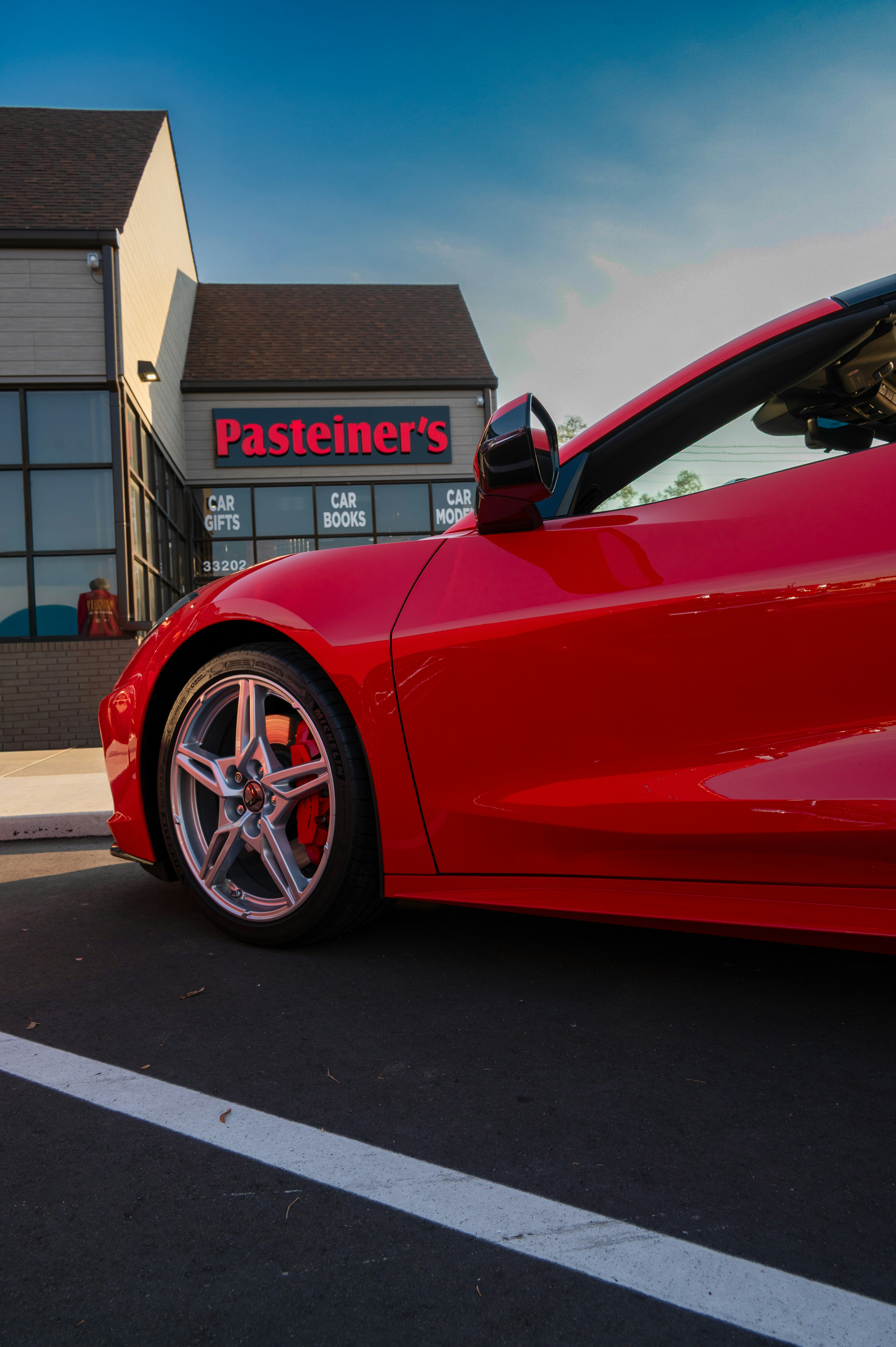 Red Streetster in the Sunlight by Pasteiner's storefront